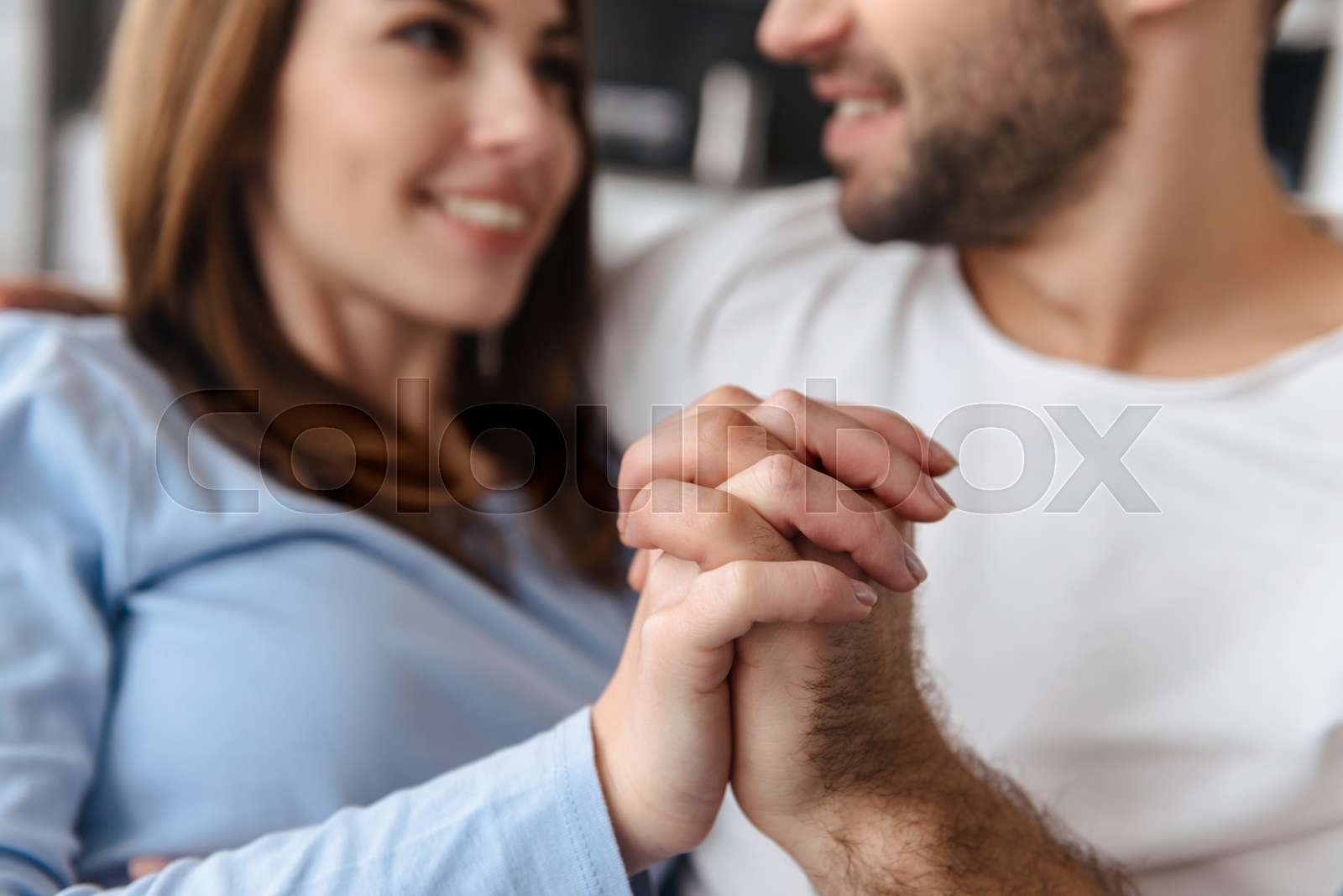 Image of attractive couple hugging together at home while sitting on ...