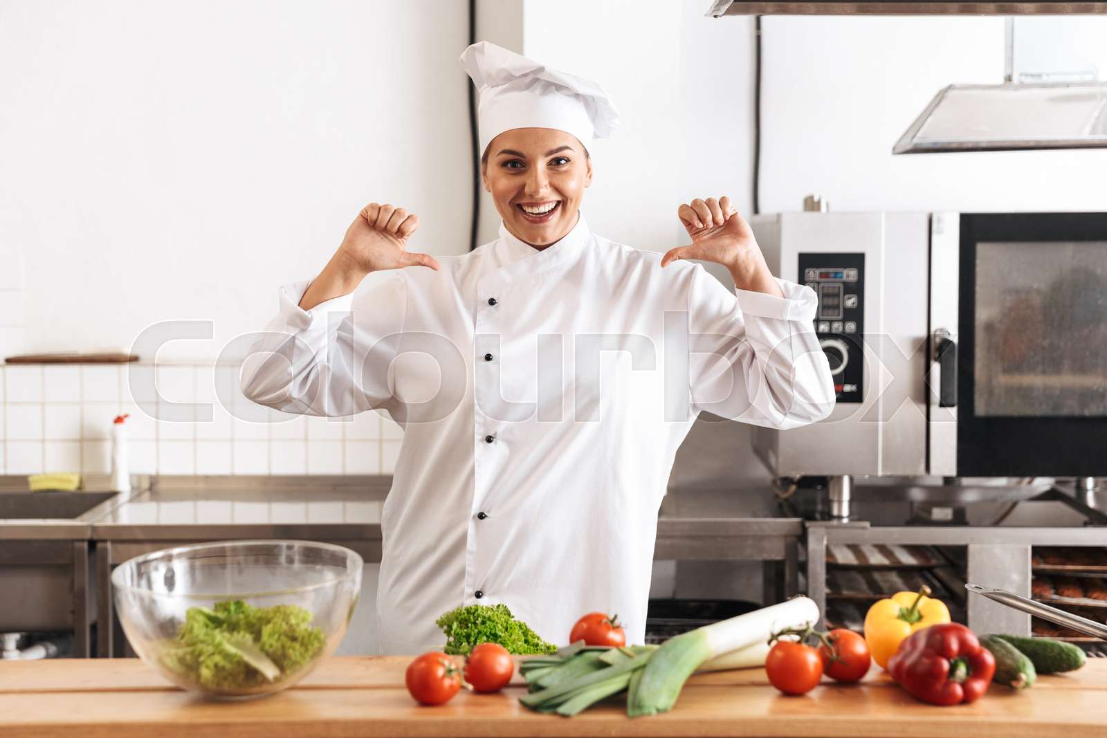Photo of smiling woman chef wearing white uniform cooking meal with ...