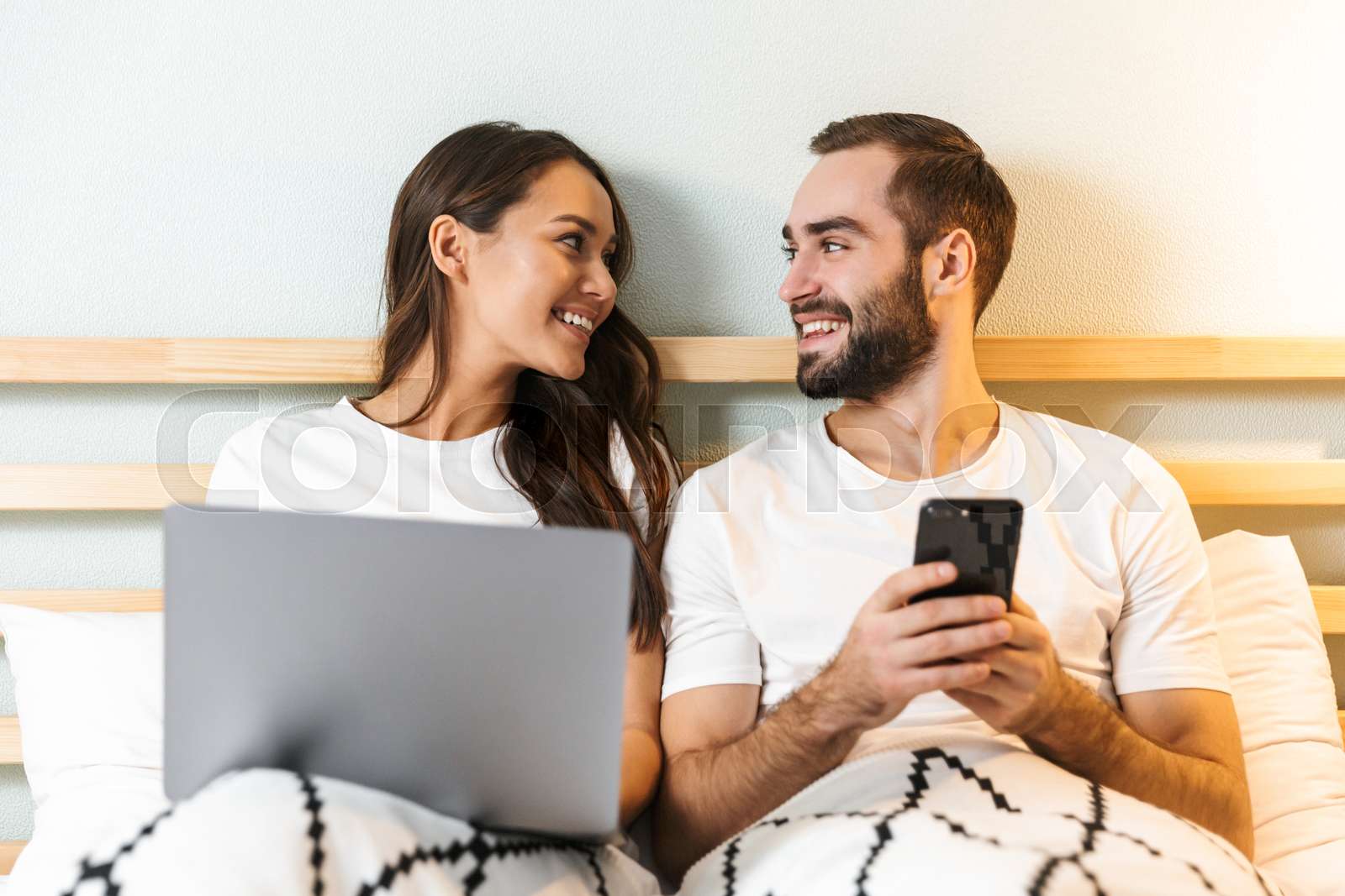 Beautiful young couple laying together in bed | Stock image | Colourbox
