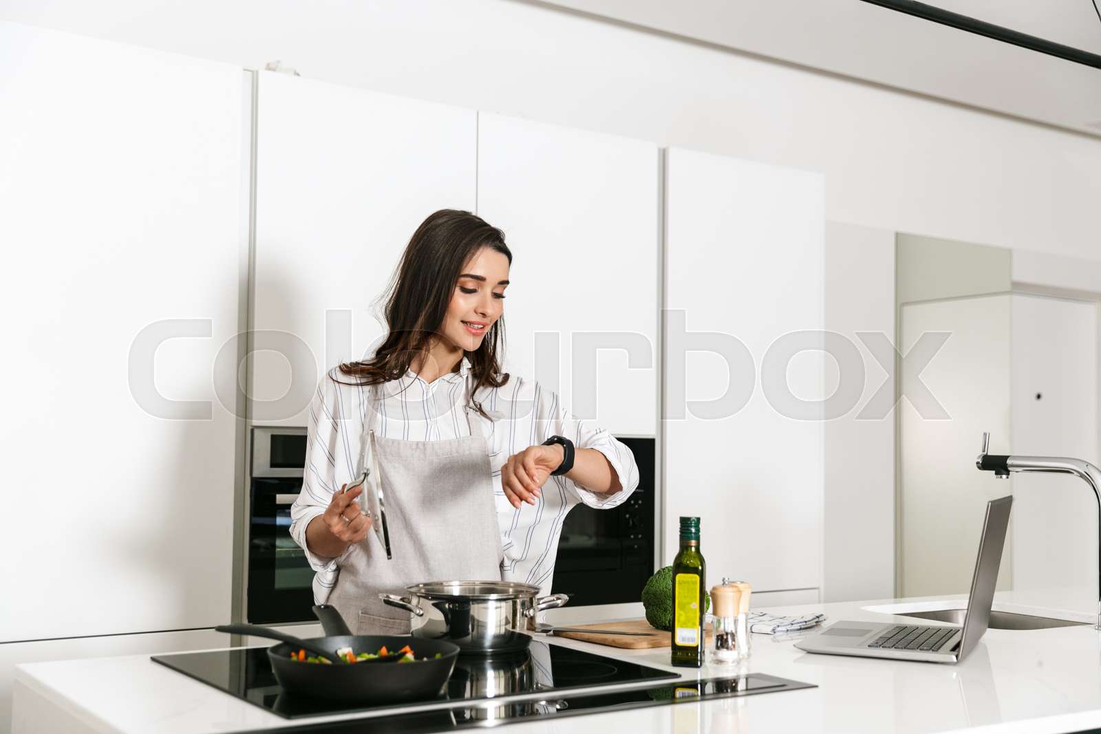 Beautiful young woman cooking healthy dinner | Stock image | Colourbox