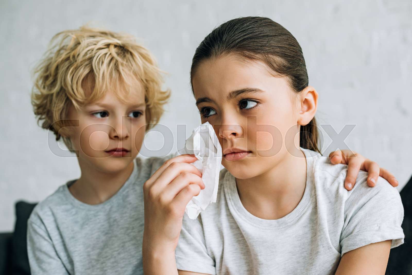 little brother consoling crying sister in living room | Stock image ...