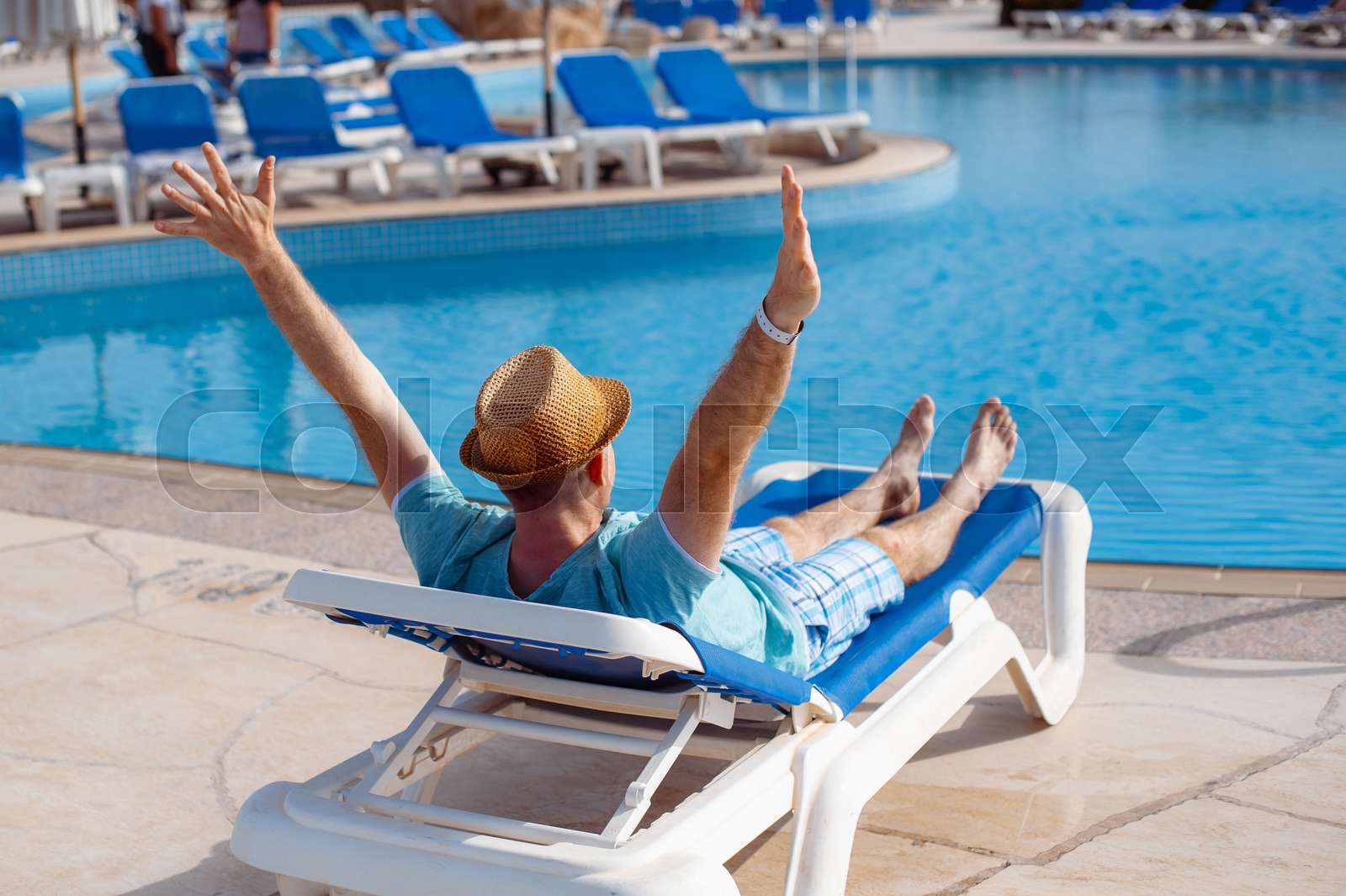 man in hat sunbathing on a sun lounger by the pool summer. Concept of ...