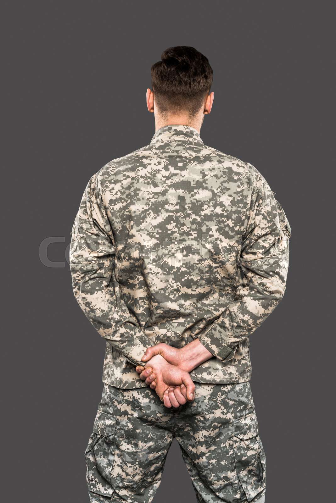 back view of soldier standing with clenched hands isolated on grey ...