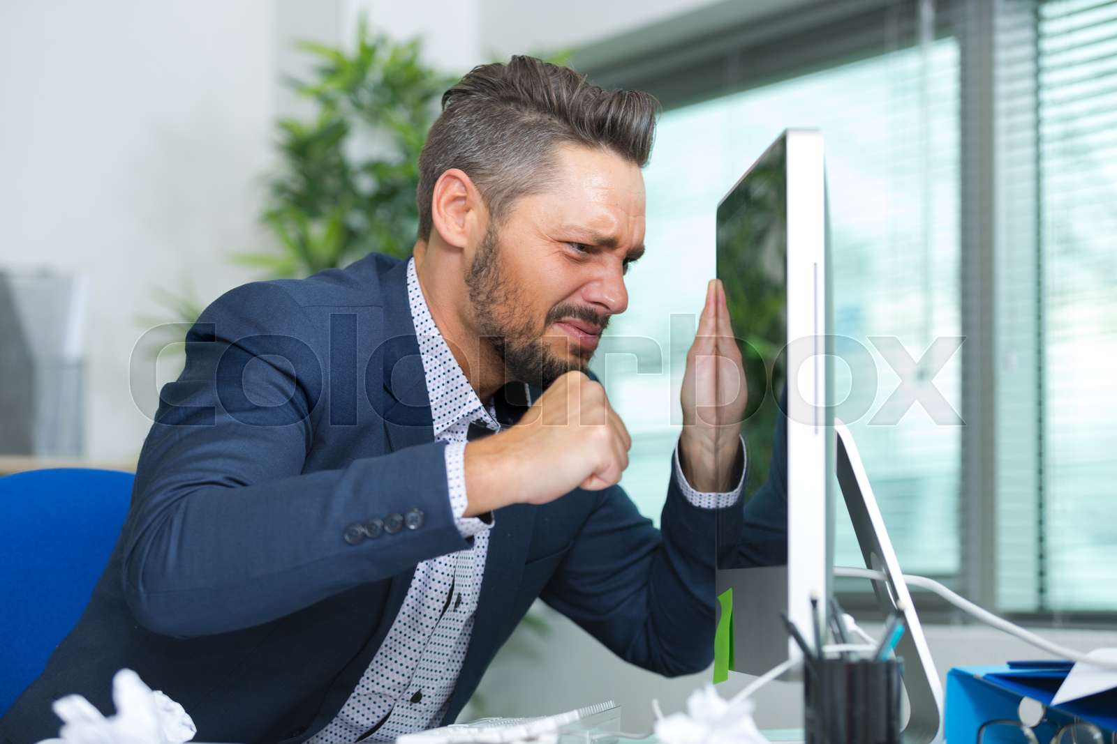 man almost punching the computer screen | Stock image | Colourbox