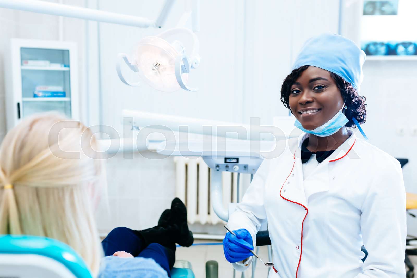 African american female dentist treating patient at clinic. Dental ...