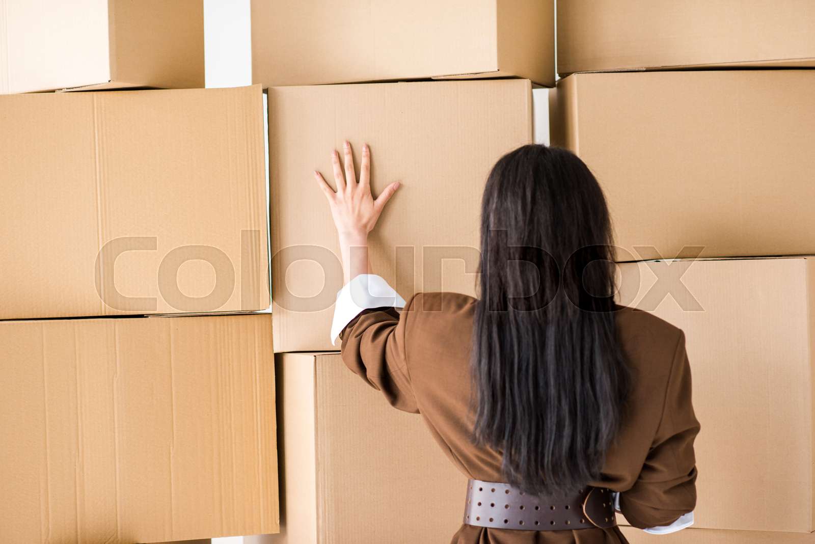 back view of brunette girl standing and touching box | Stock image ...