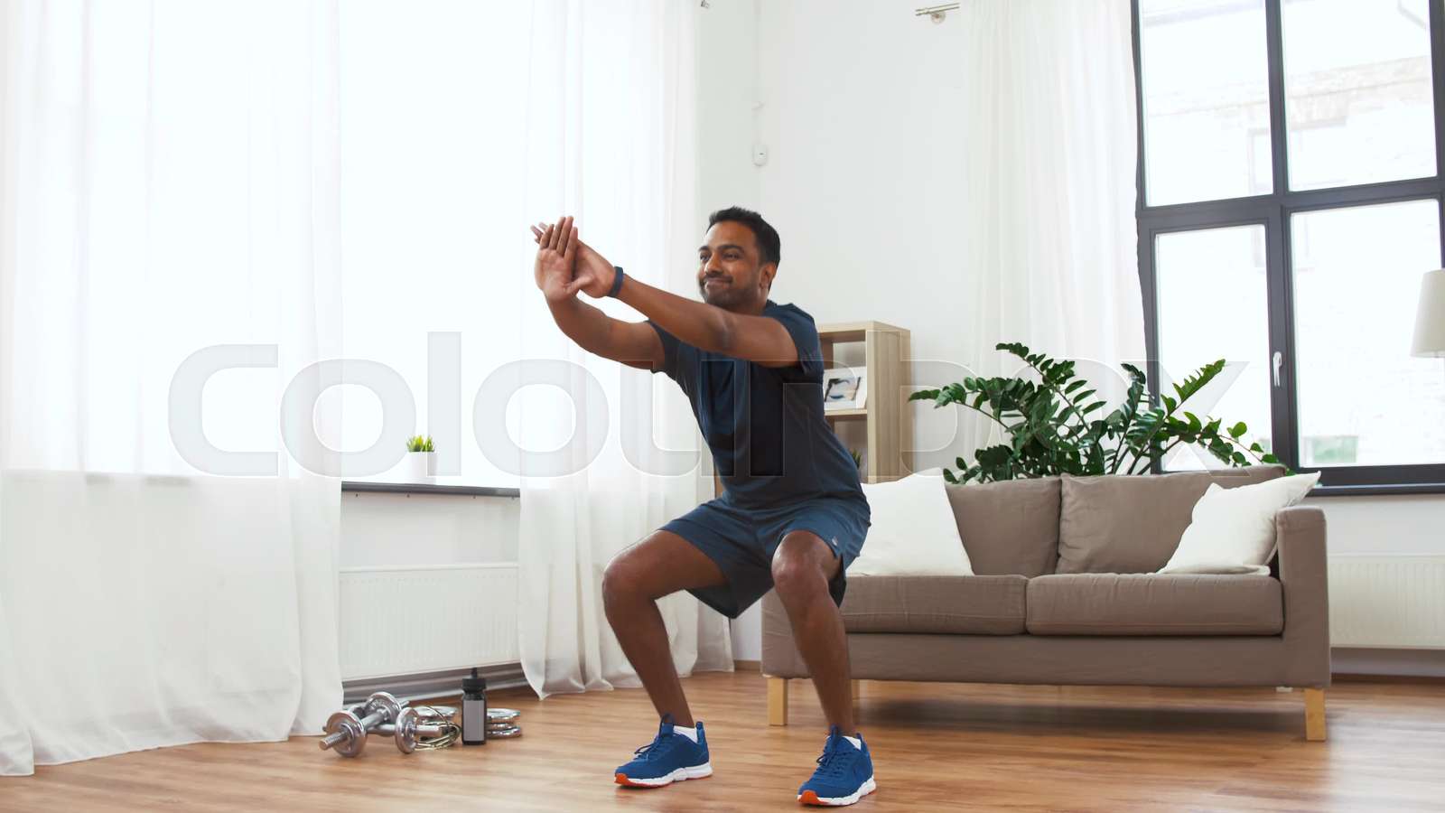 indian man exercising and doing squats at home | Stock video | Colourbox