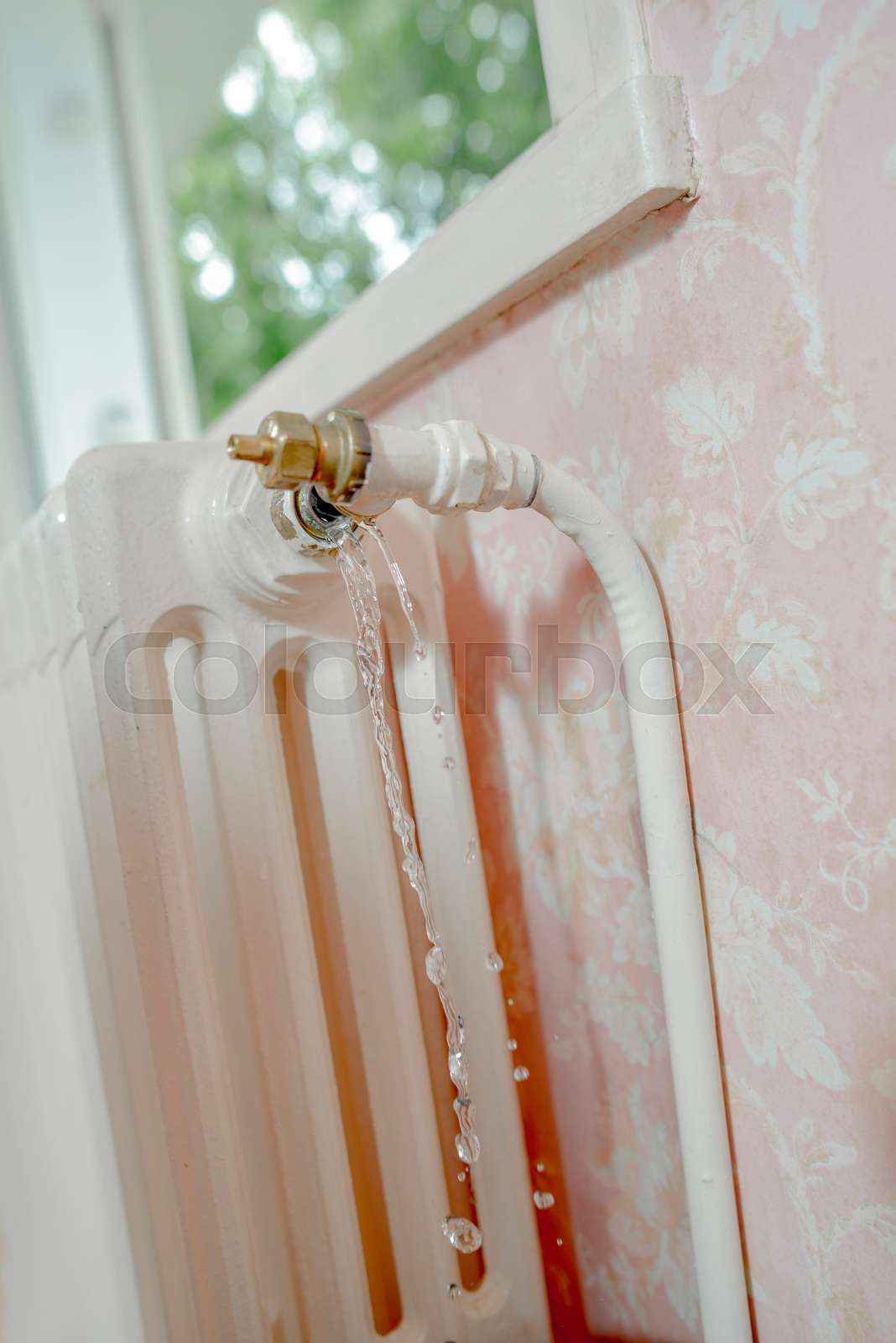 male worker is fixing a leaky radiator | Stock image | Colourbox