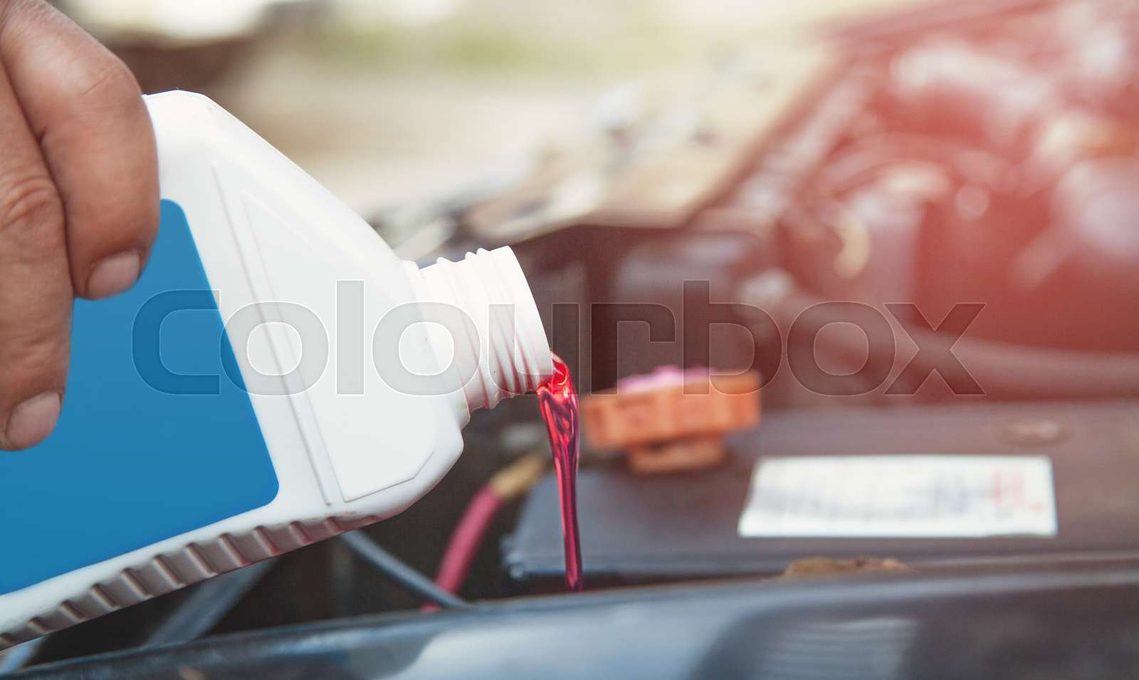 Pouring motor oil into the engine. | Stock image | Colourbox