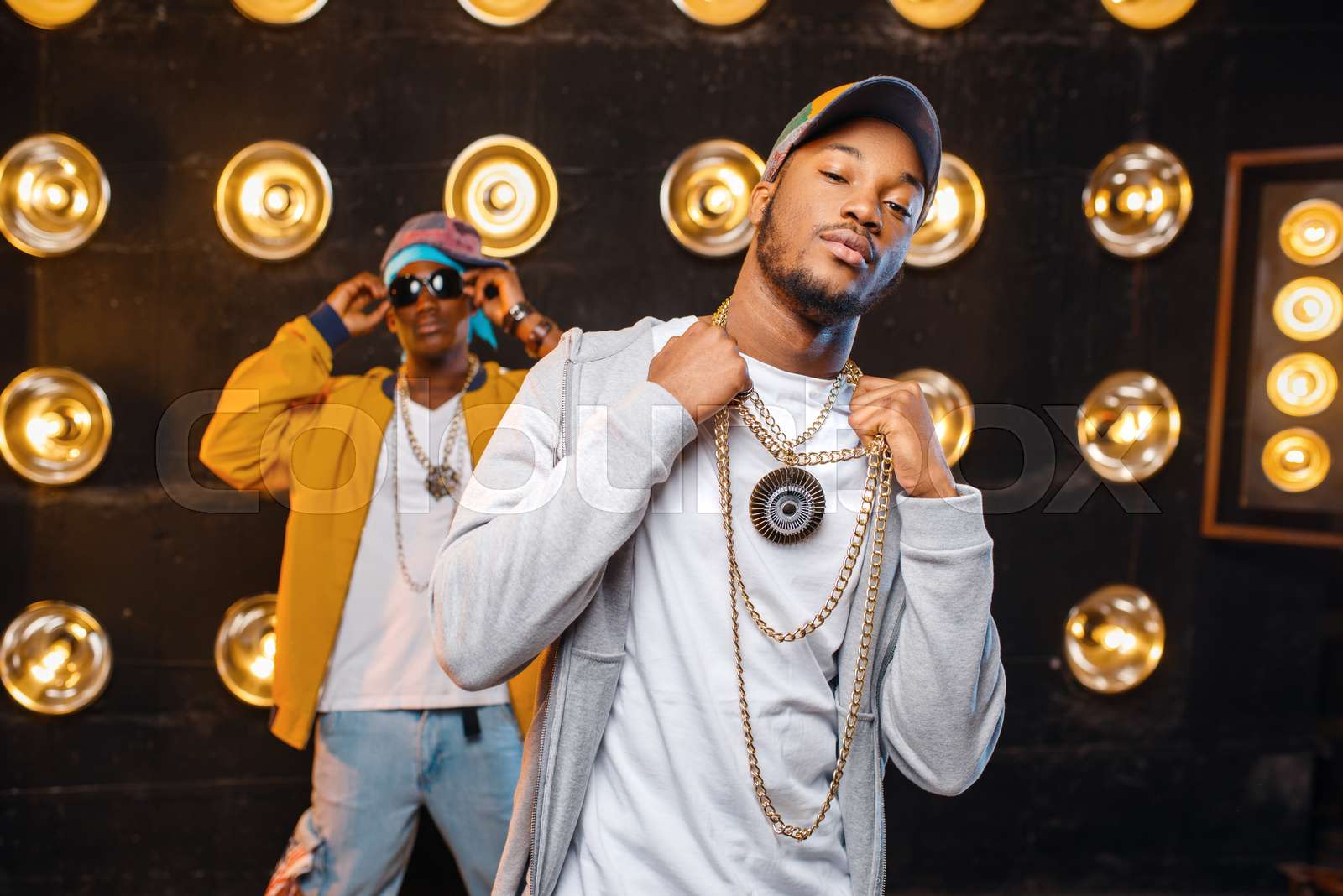 Two black rappers in caps on stage with spotlights | Stock image ...