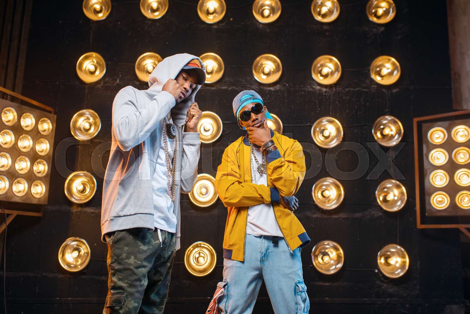 Two black rappers in caps on stage with spotlights | Stock image ...