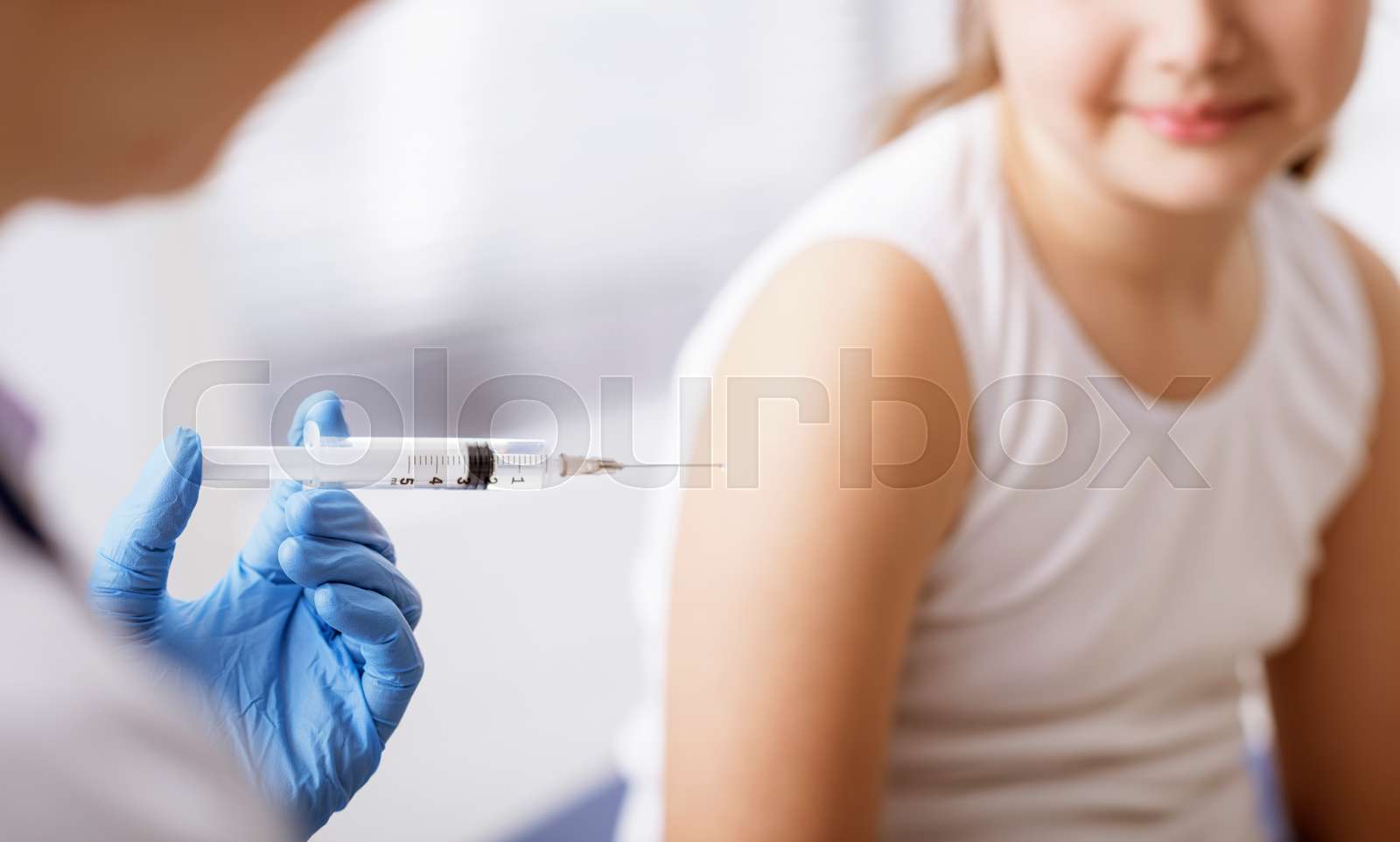 Doctor giving an injection to a young patient | Stock image | Colourbox