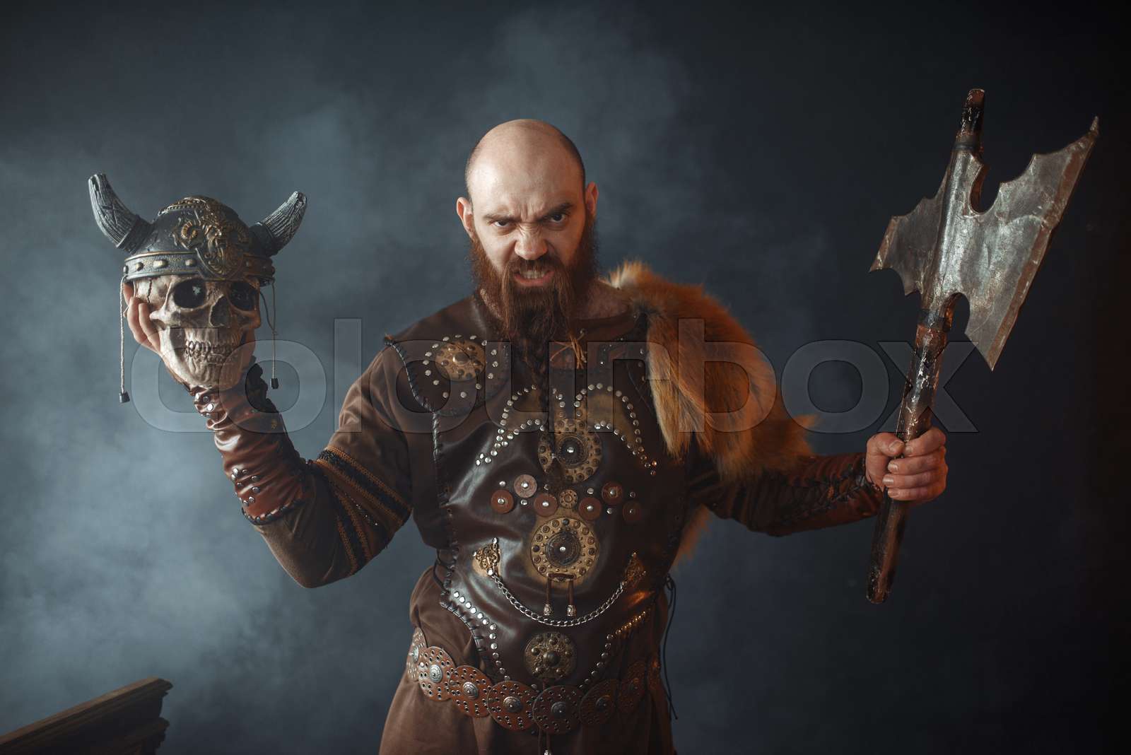 Angry viking holds enemy's skull in helmet and axe | Stock image ...