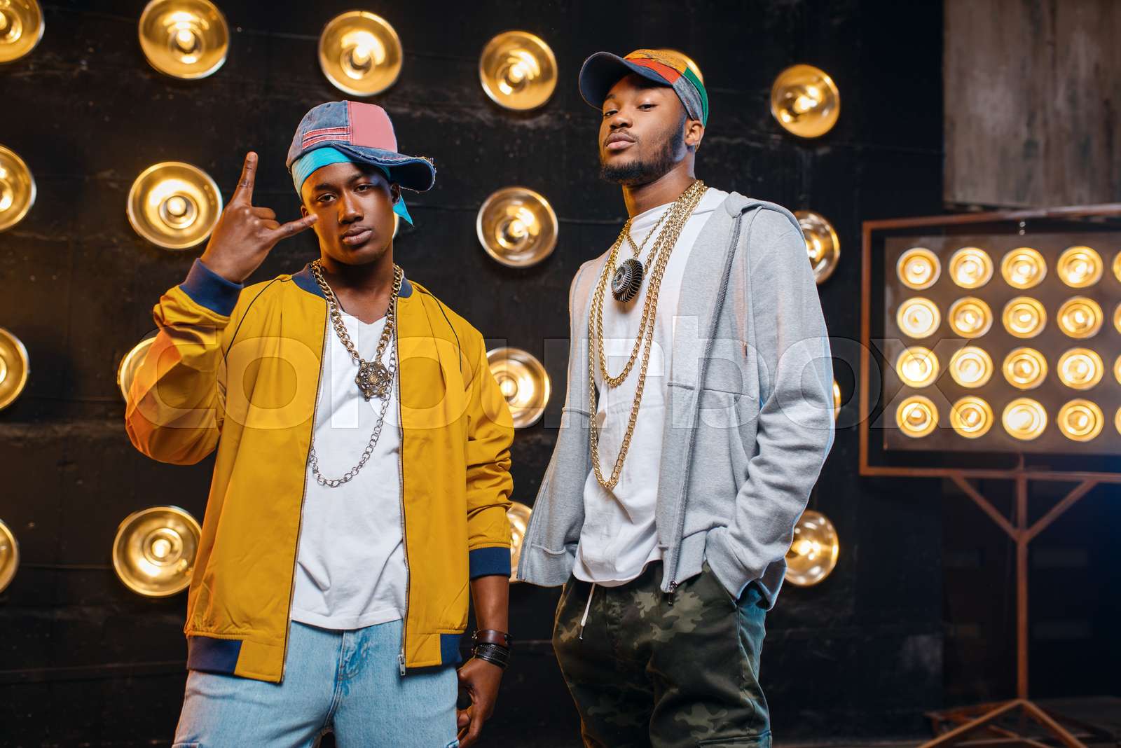 Black rappers in caps on stage with spotlights | Stock image | Colourbox