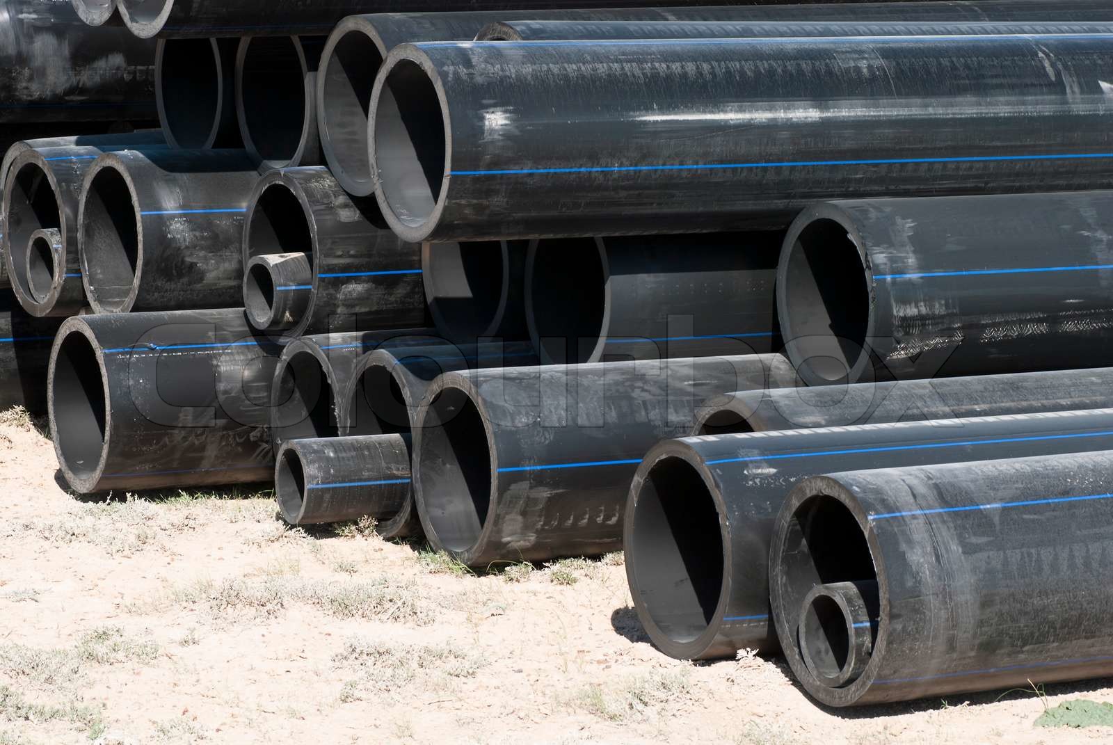 Pipes for water in a stack on field | Stock image | Colourbox