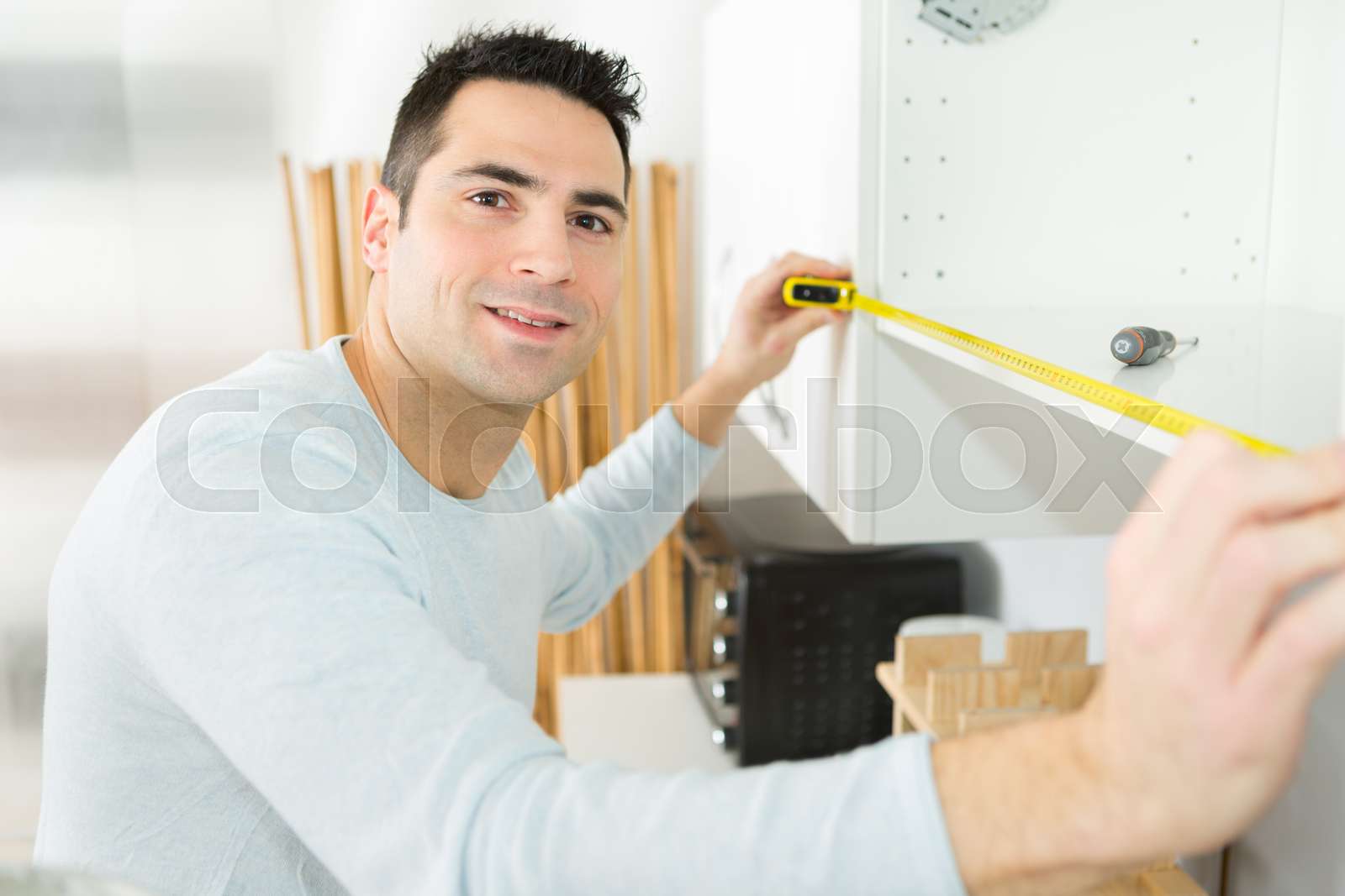 man measuring the cupboard | Stock image | Colourbox