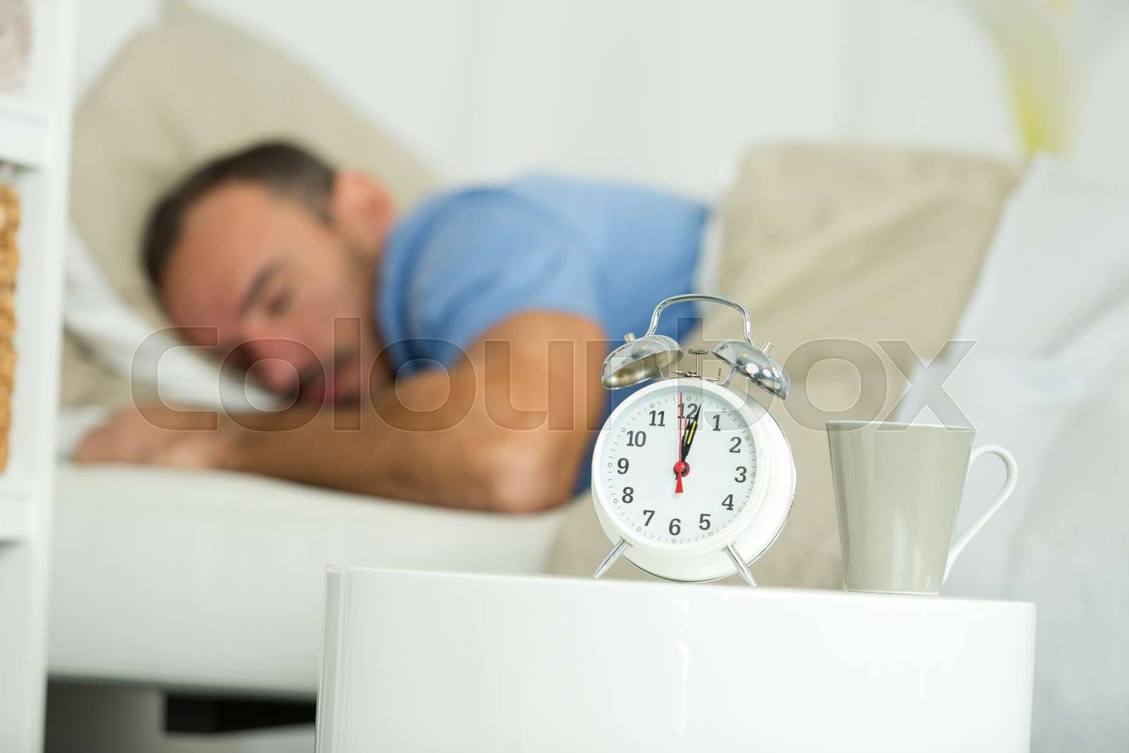 man asleep in bed alarm clock showing twelve oclock | Stock image ...