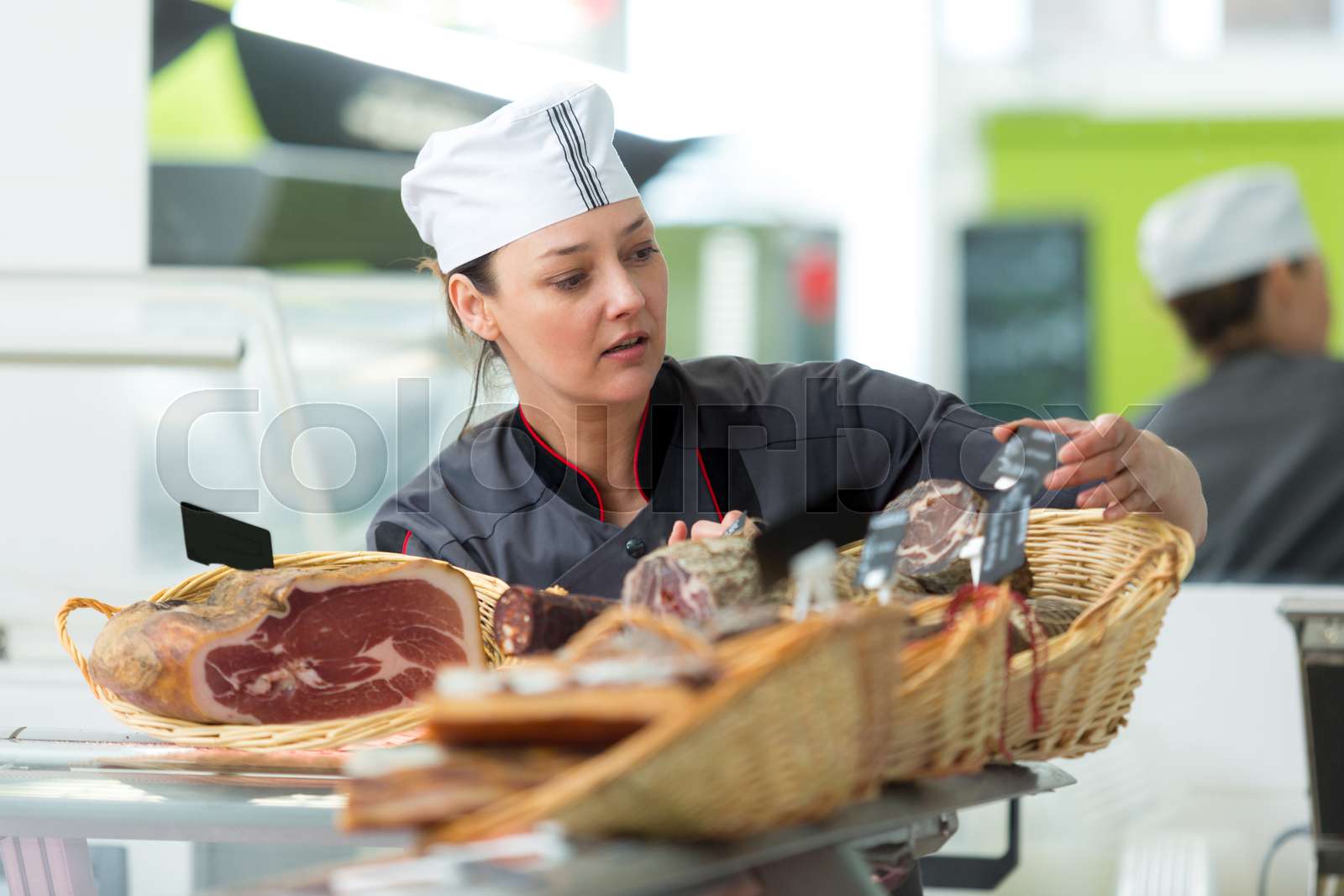 female butcher tyding up salami | Stock image | Colourbox