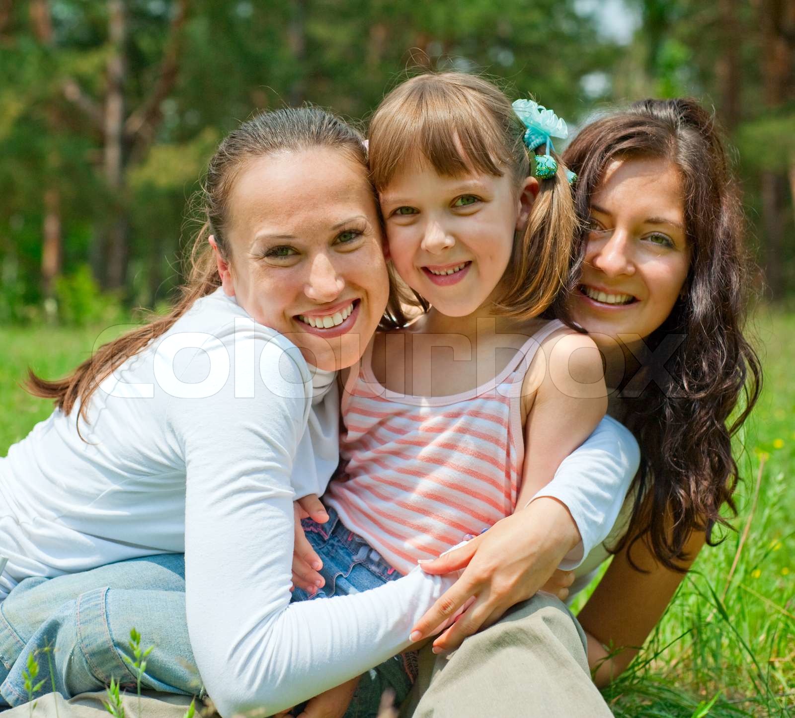three smiley sisters at the green grass | Stock image | Colourbox