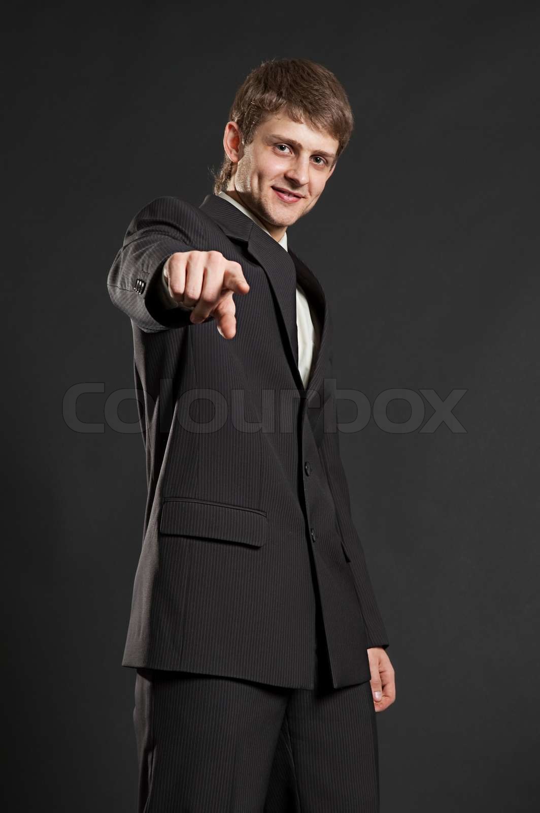young businessmen in black suit pointing | Stock image | Colourbox