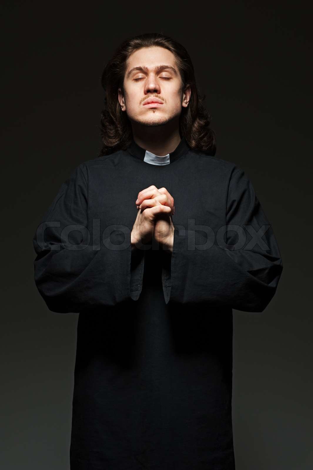 young priest is praying | Stock image | Colourbox