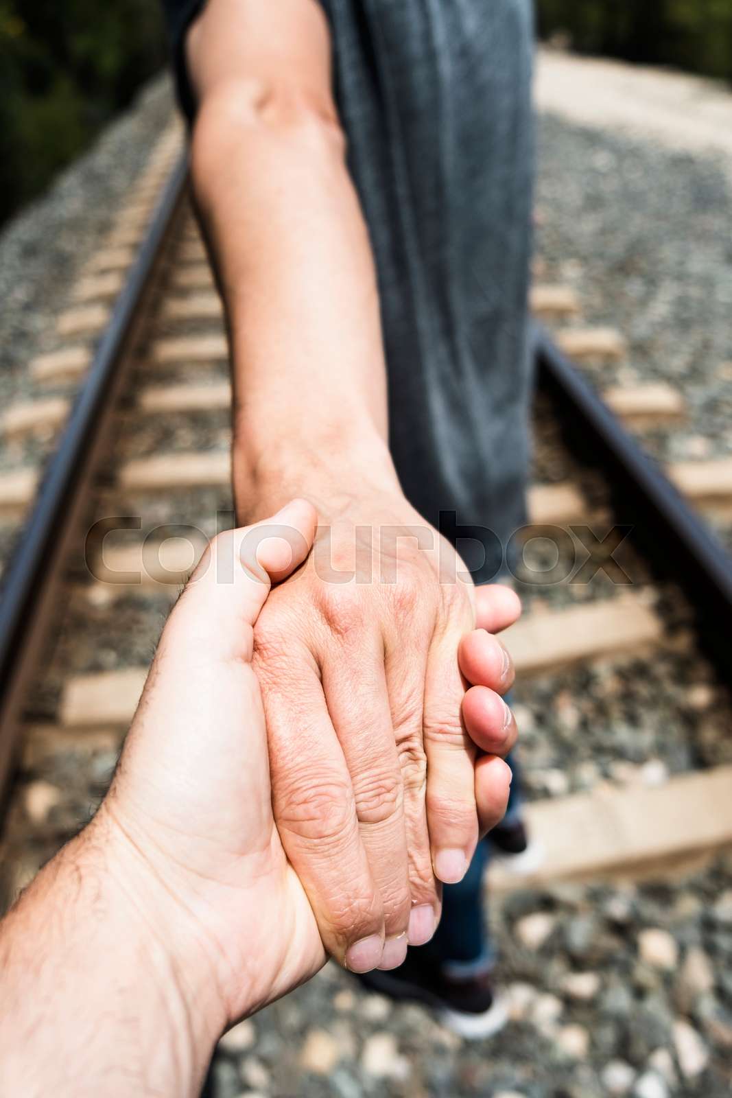 men holding hands on the railroad tracks | Stock image | Colourbox