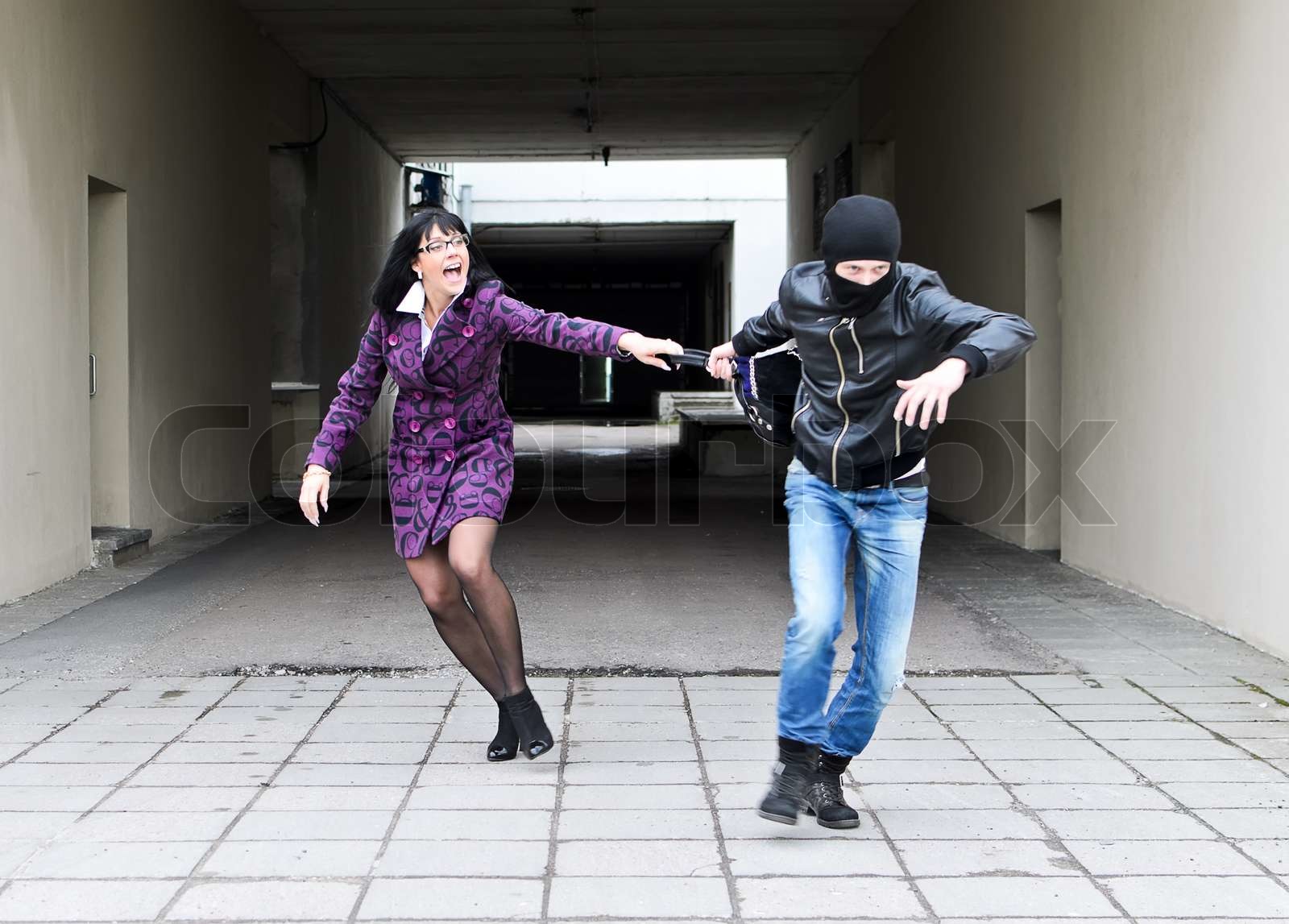 Daylight robbery on the street Thief steals a bag | Stock image | Colourbox
