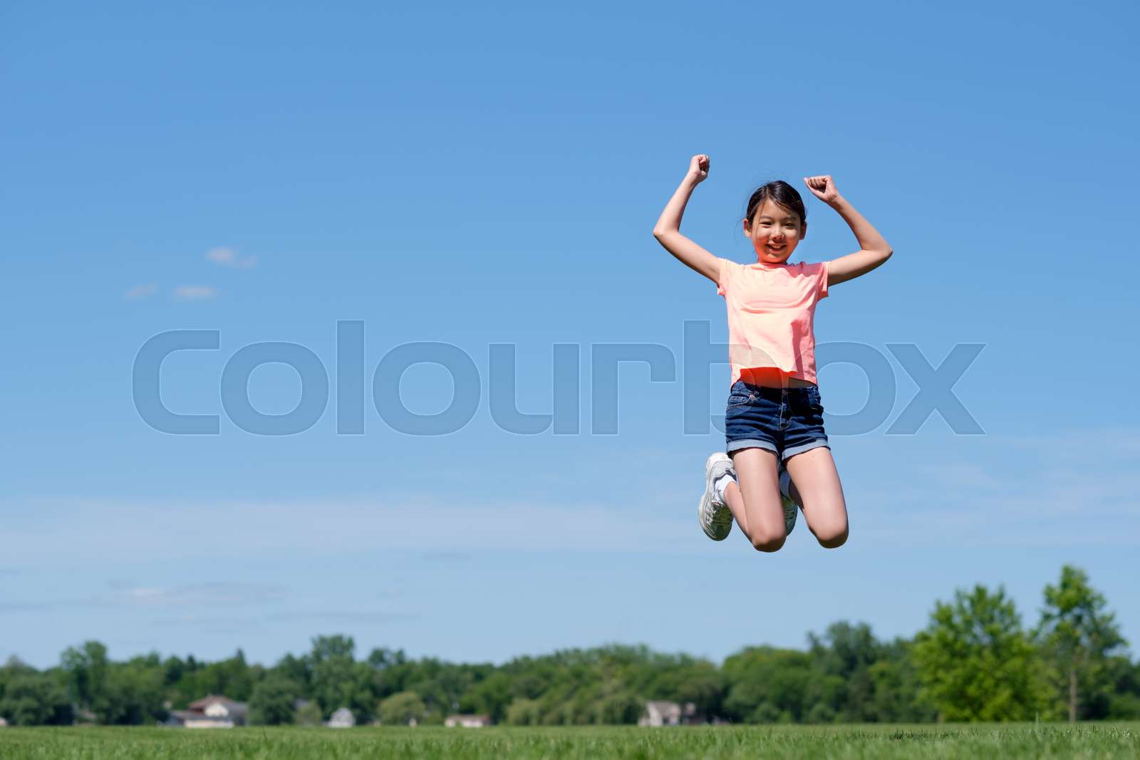 Happy Asian teen girl jumping high in air | Stock image | Colourbox