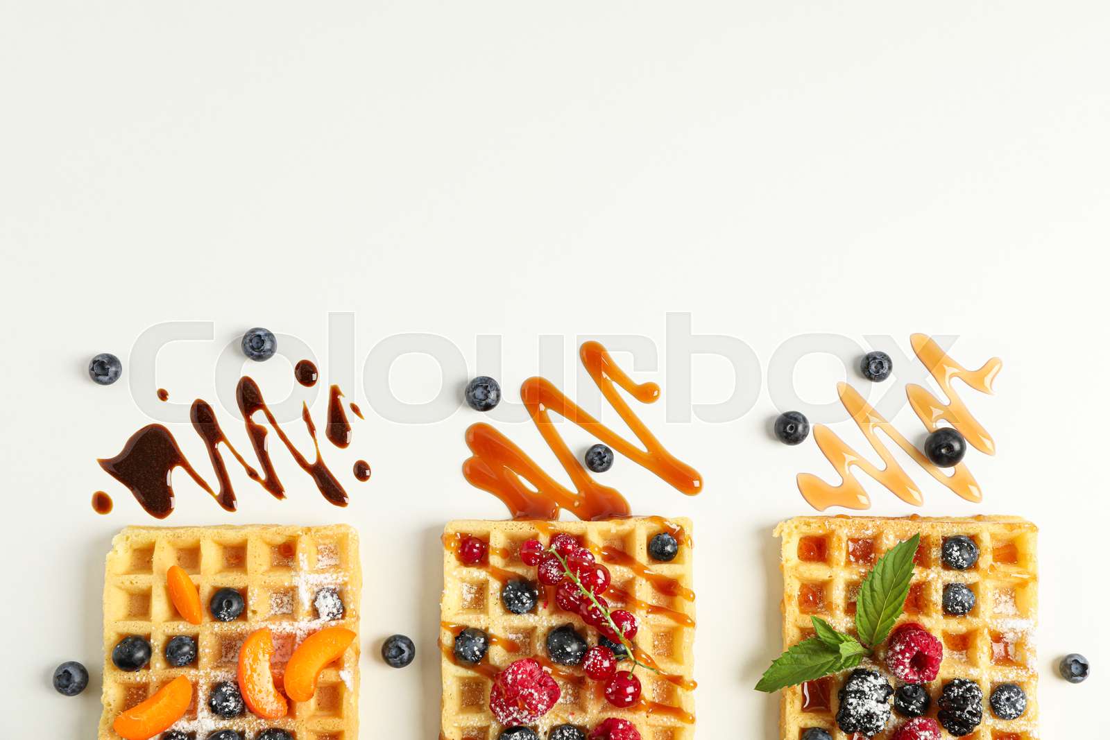 Flat lay composition with belgian waffles and different toppings, top view | Stock image | Colourbox