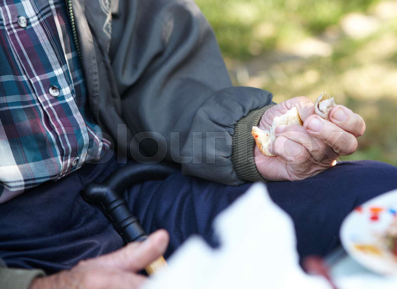 Elderly poor man eating bread | Stock image | Colourbox