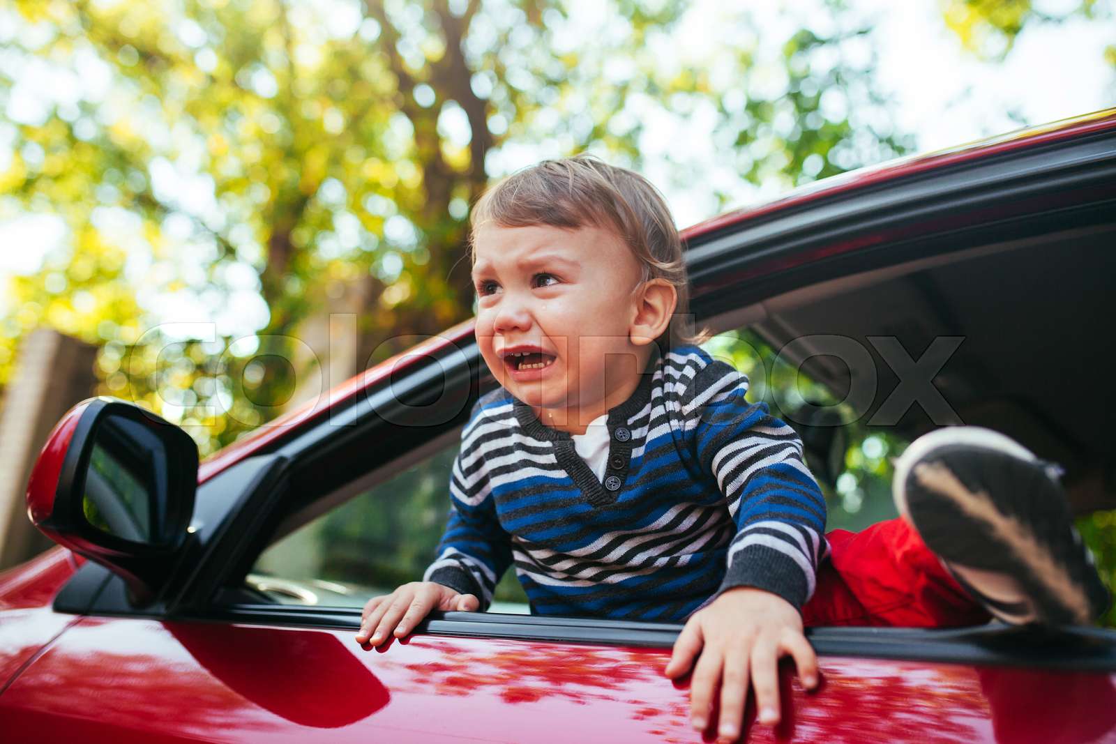 Crying baby boy in car. The boy is crying and wants to get out of the ...