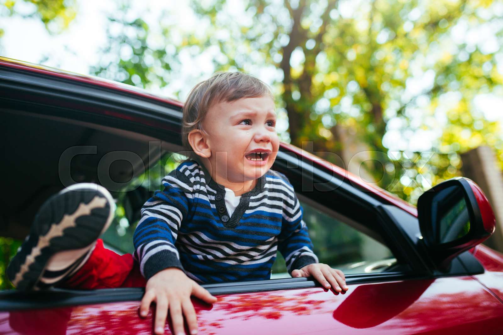 Crying baby boy in car. The boy is crying and wants to get out of the ...