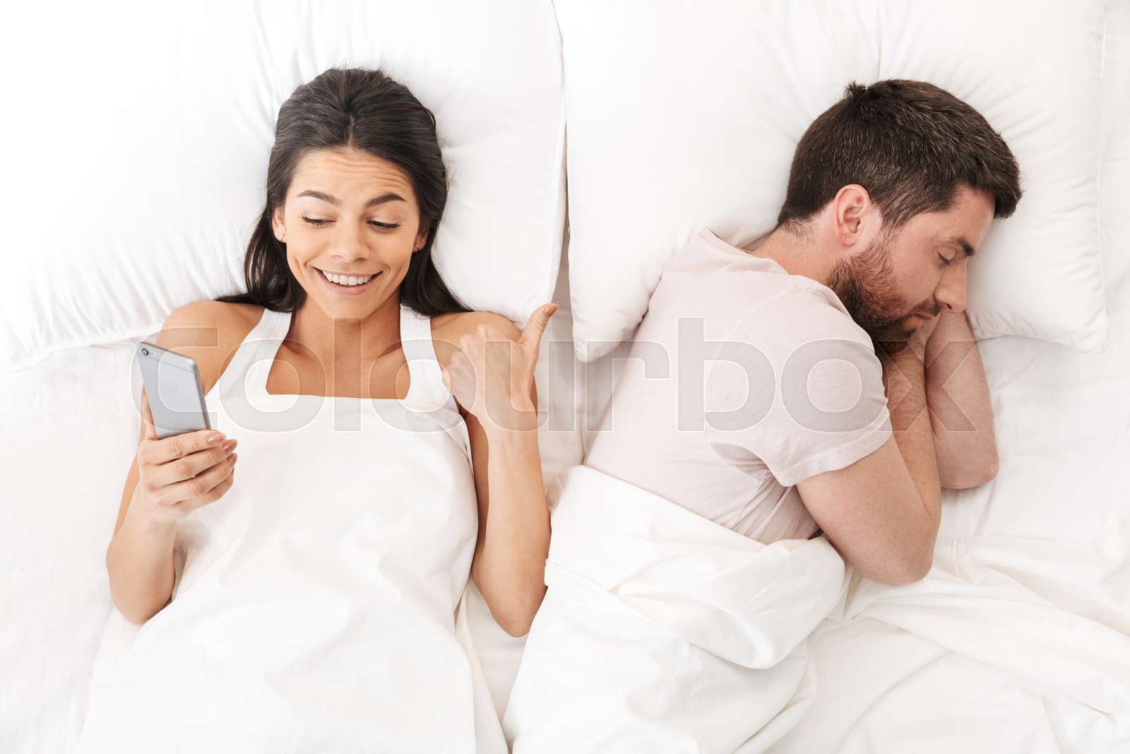 Portrait of a beautiful young couple laying in bed | Stock image ...