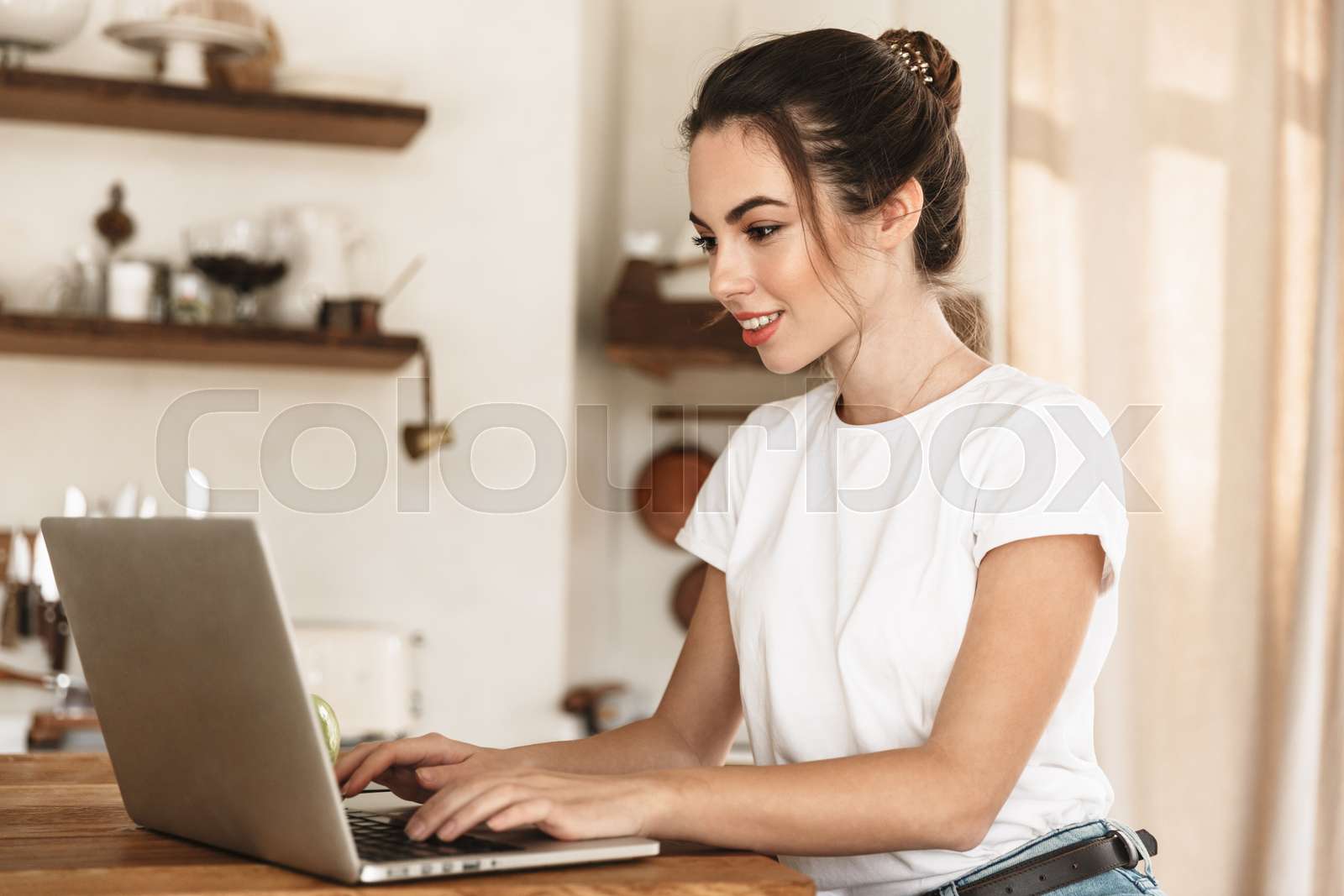 Beautiful young student girl sitting indoors using laptop computer ...
