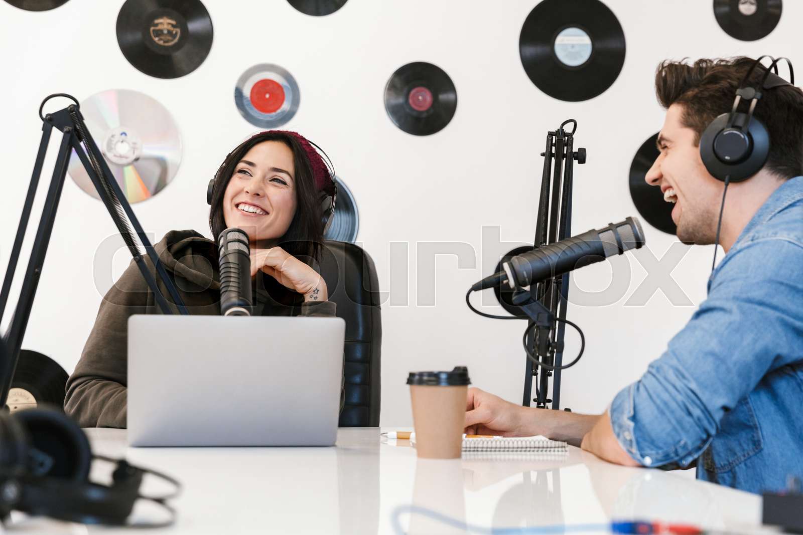 Young man radio host with colleague woman at the workspace with ...