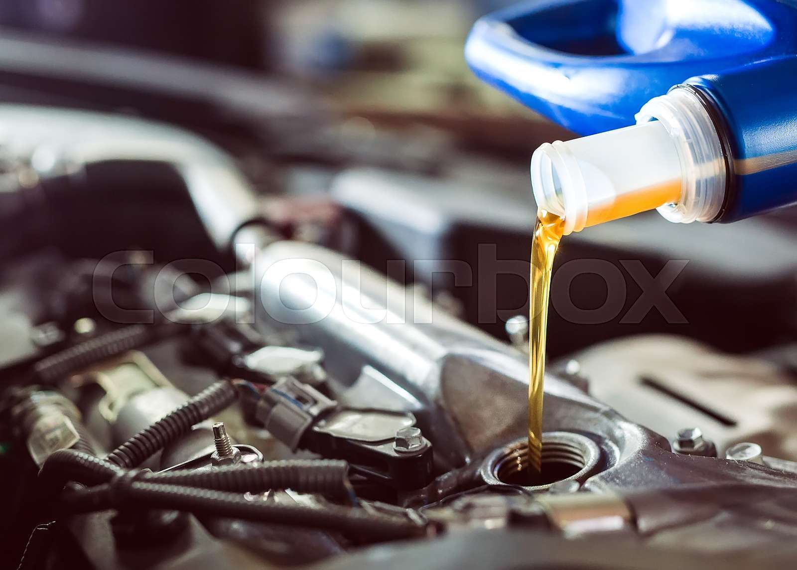 Motor oil pouring to car engine. Repair service. | Stock image | Colourbox