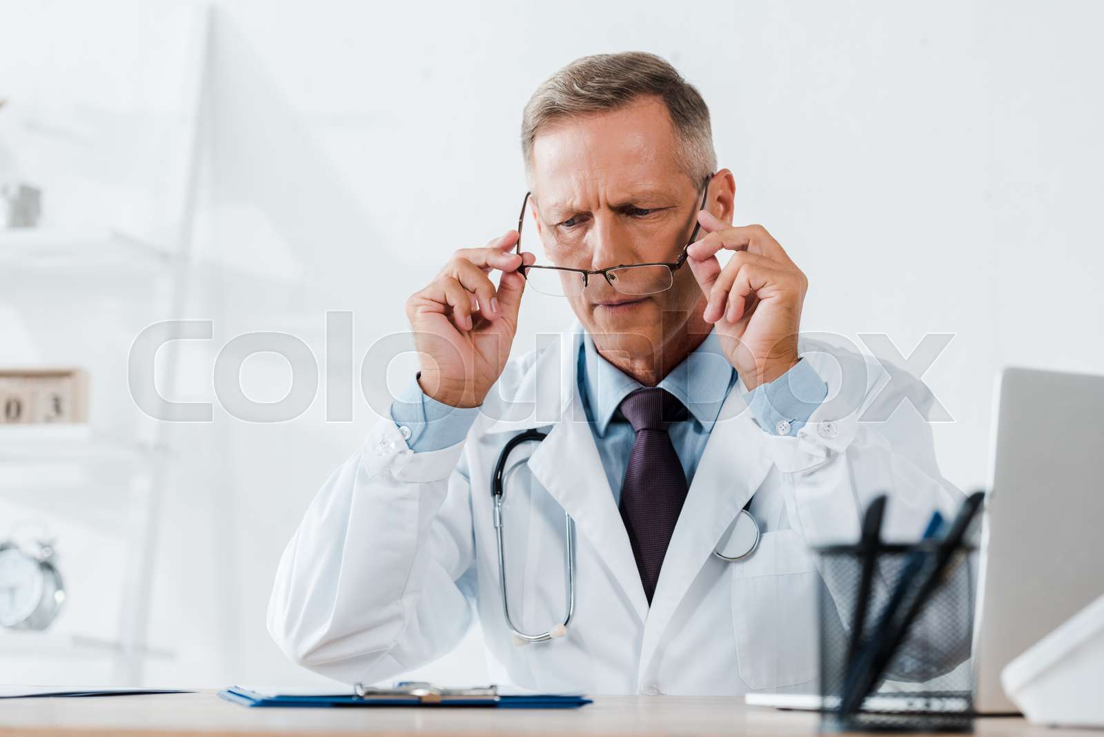 selective focus of handsome doctor touching glasses in hospital | Stock ...