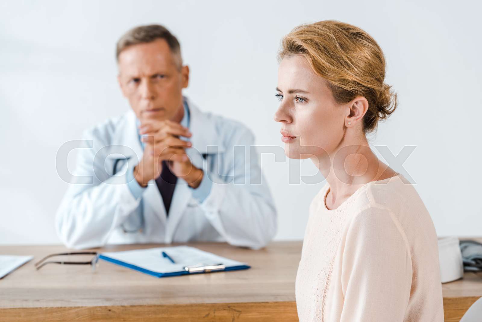selective focus of upset woman sitting near doctor in white coat ...