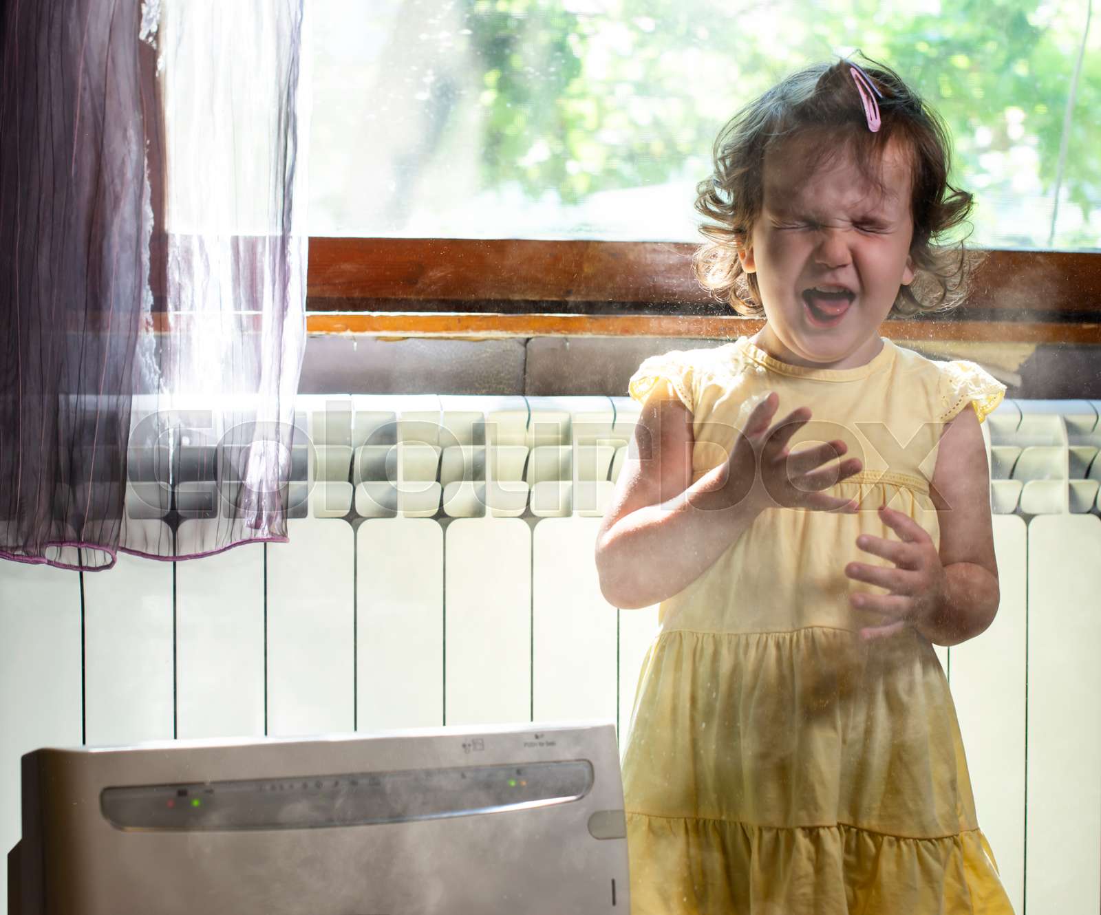 Little girl in a dusty room. Air purifier and coughing kid. Dust in the ...