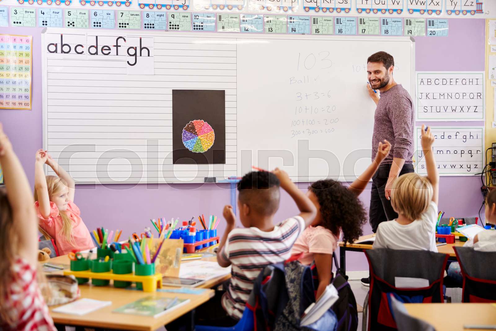 Pupils Raising Hands To Answer Question In Elementary School Maths ...