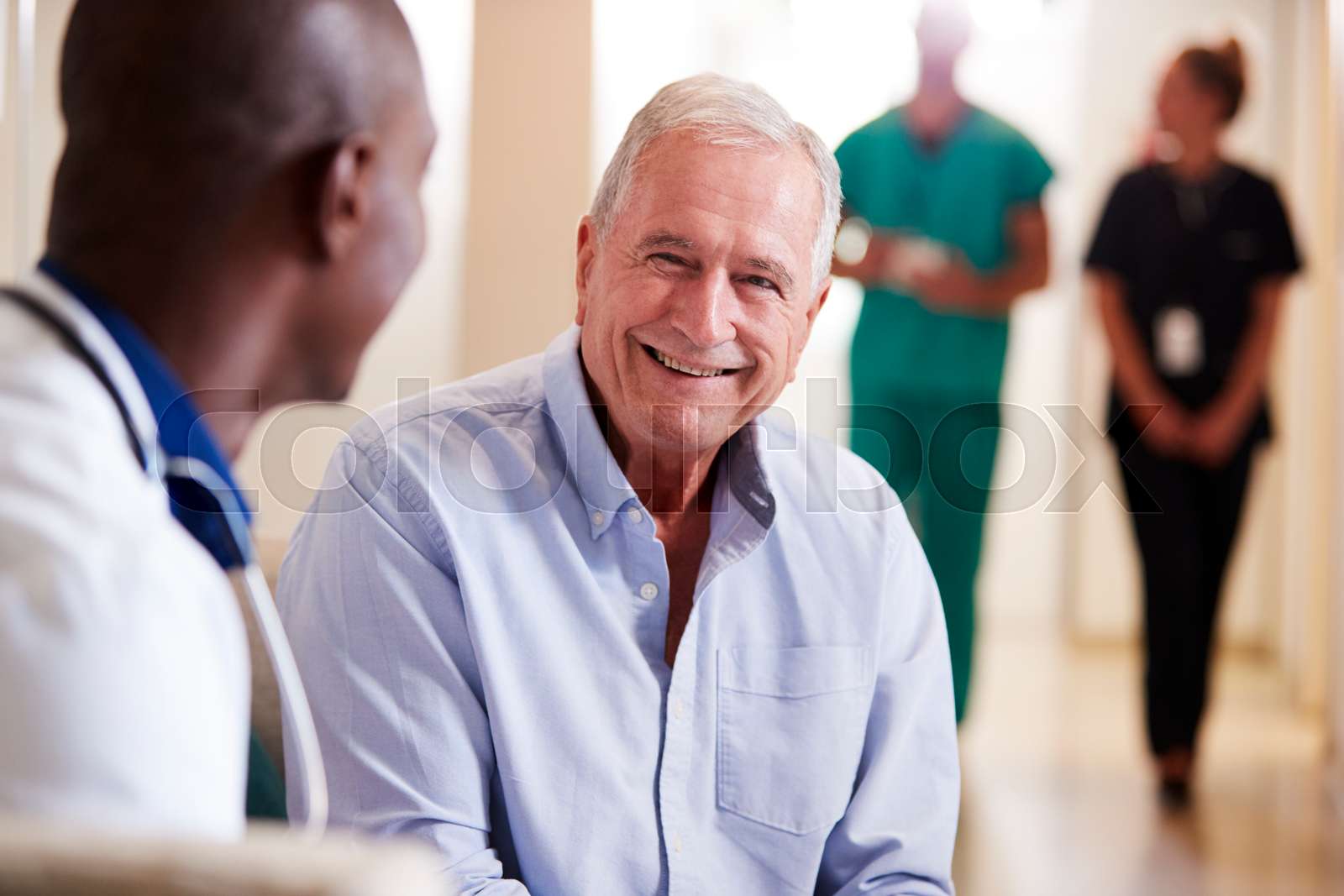 Doctor Welcoming To Senior Male Patient Being Admitted To Hospital ...