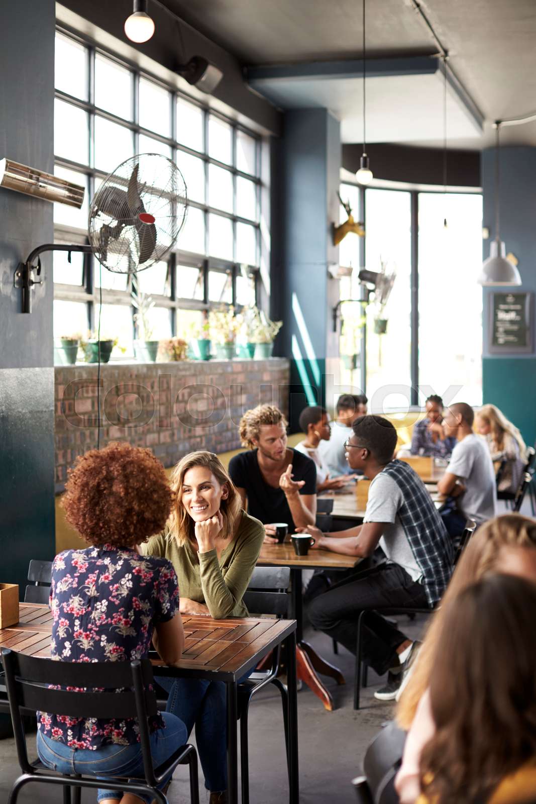 Interior Of Busy Coffee Shop With Customers Sitting At Tables | Stock ...