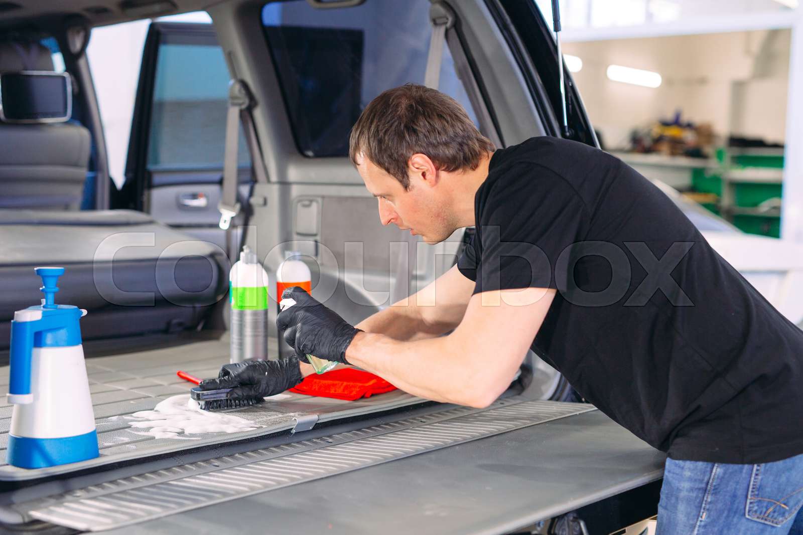 Car chemist. Chemical treatment of the car trunk. | Stock image | Colourbox
