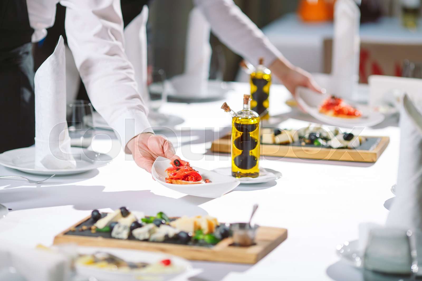 Waiter serving table in the restaurant preparing to receive guests ...