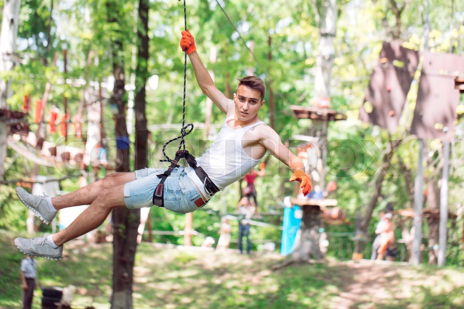 Man spend their leisure time in a ropes course. Man engaged in rope ...