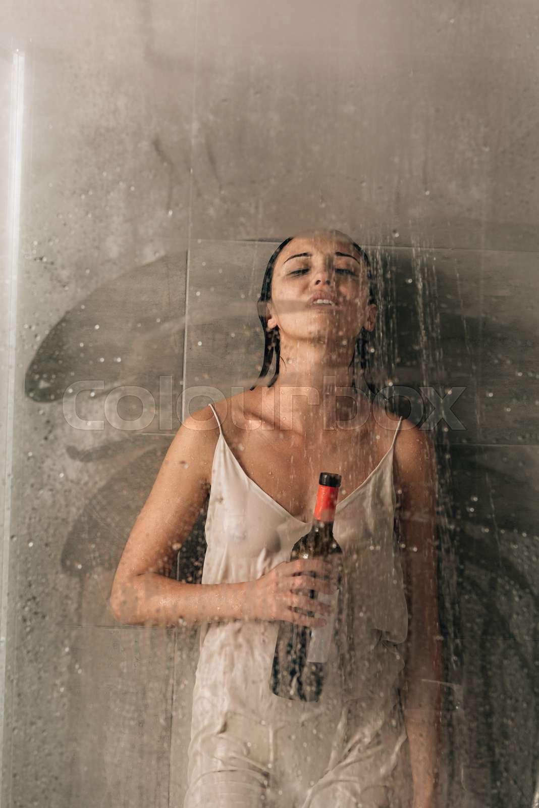 lonely depressed woman in shower with wine at home | Stock image ...