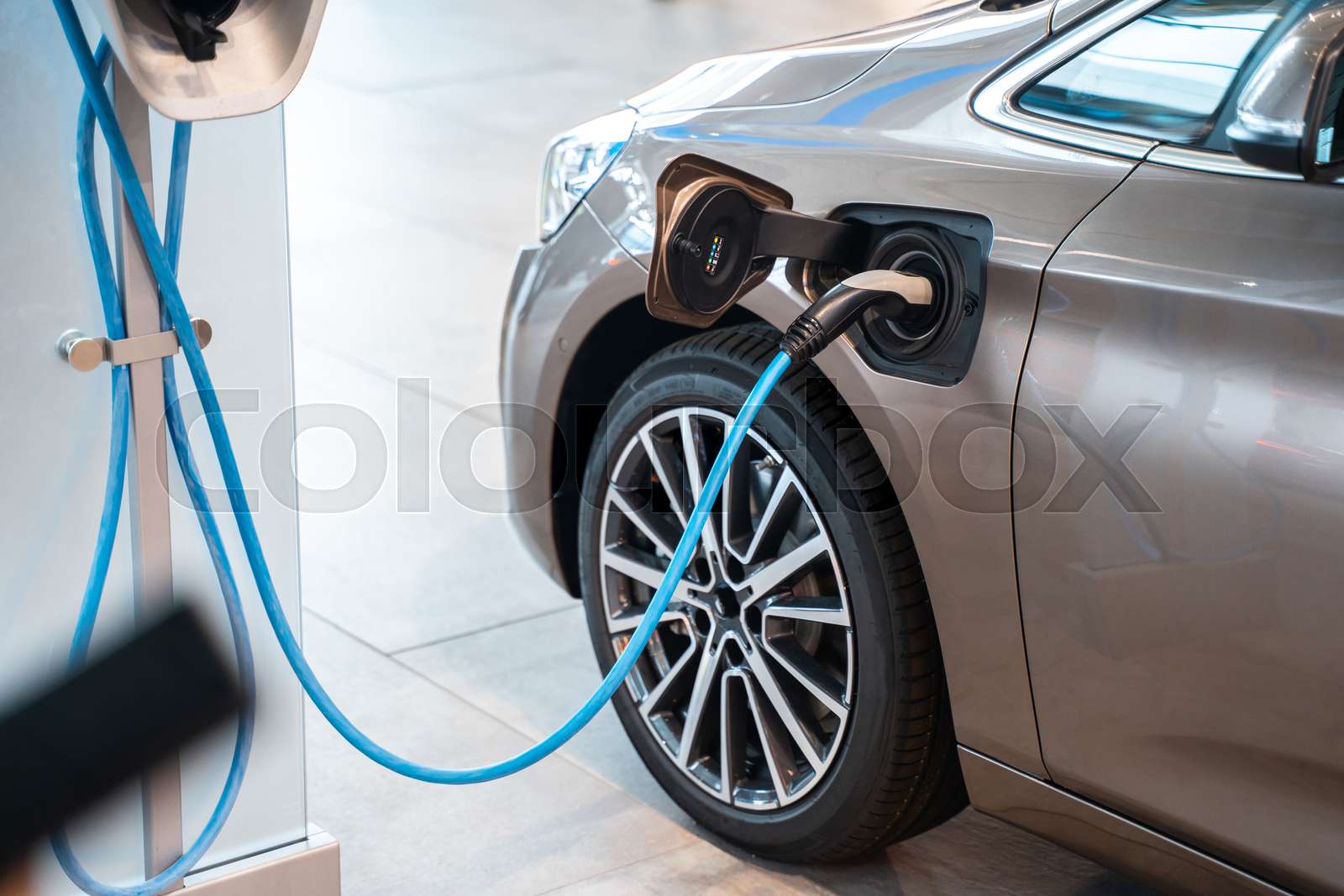 Power supply plugged into an electric car being charged. | Stock image ...