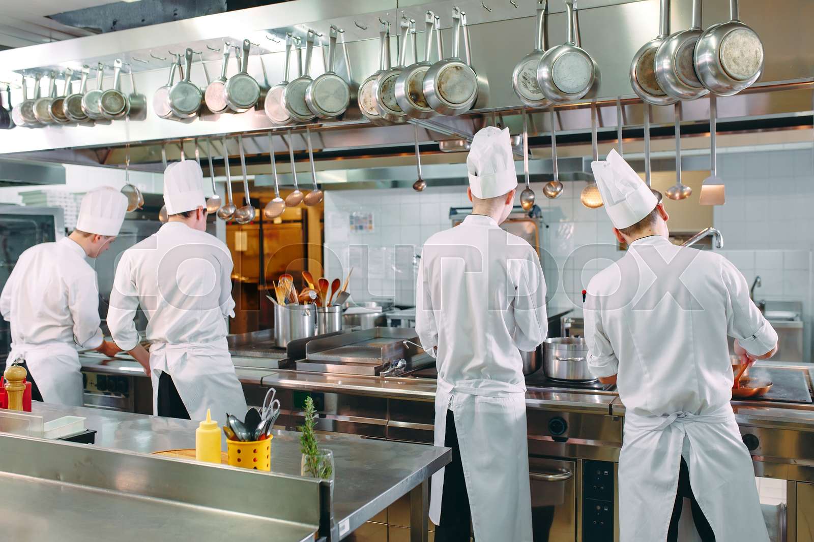 Modern kitchen. Cooks prepare meals on the stove in the kitchen of the ...