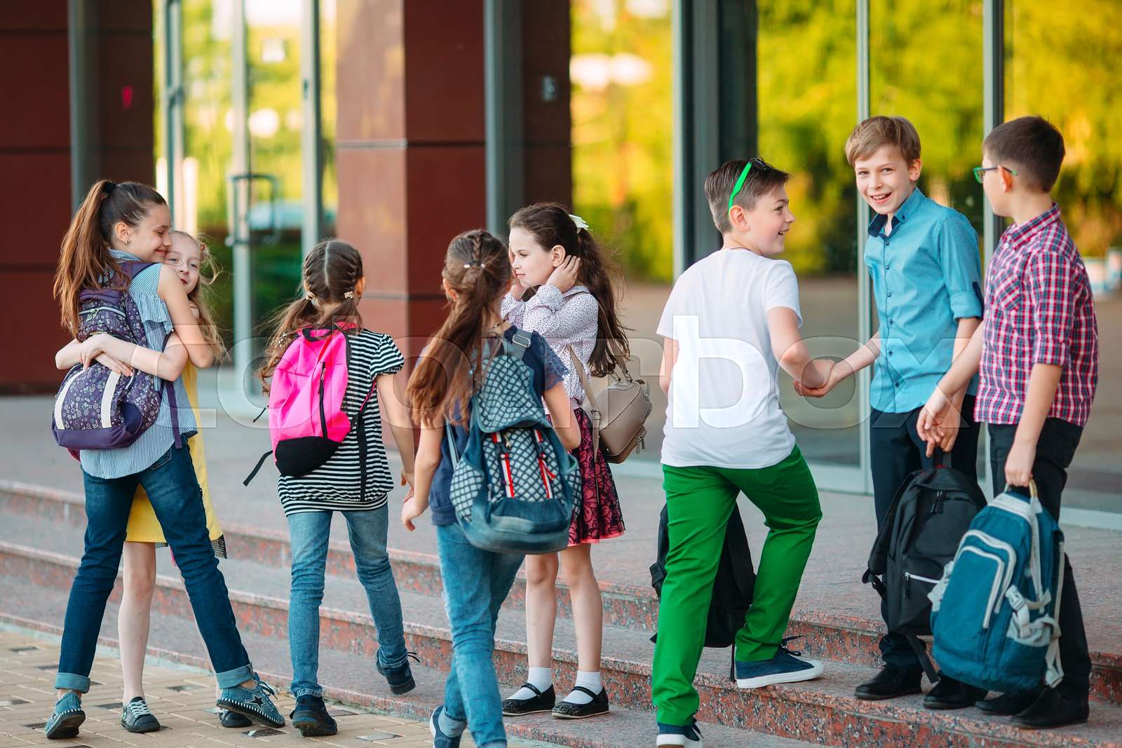 Schoolmates go to school. Students greet each other. | Stock image ...