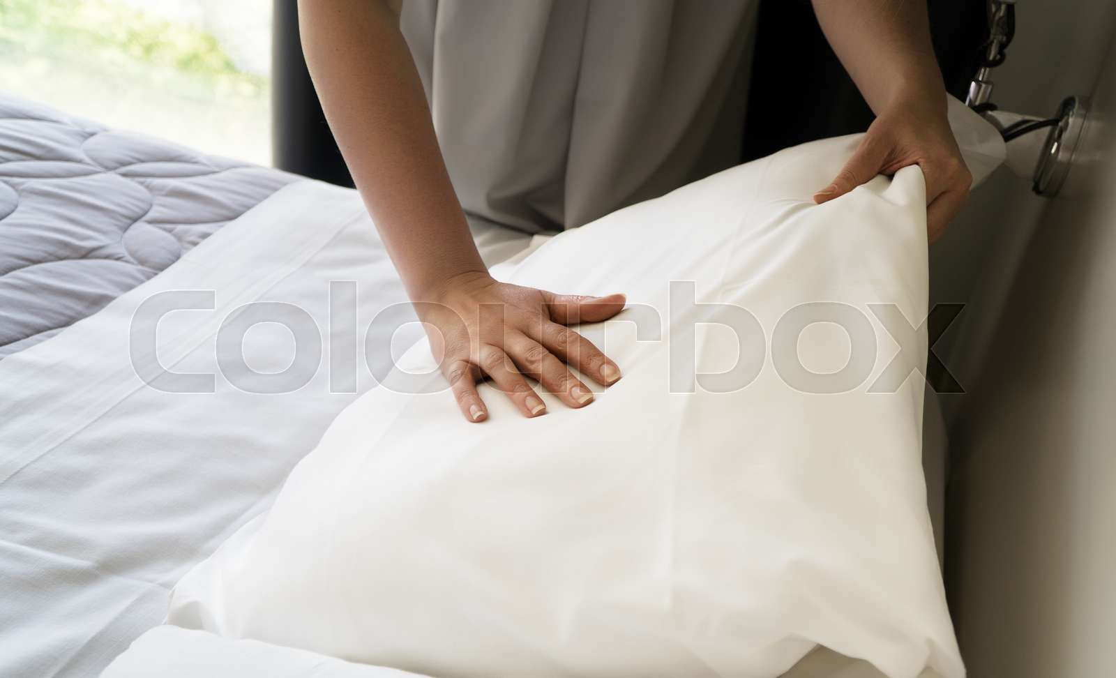 Room service. Woman making bed in hotel room. | Stock image | Colourbox